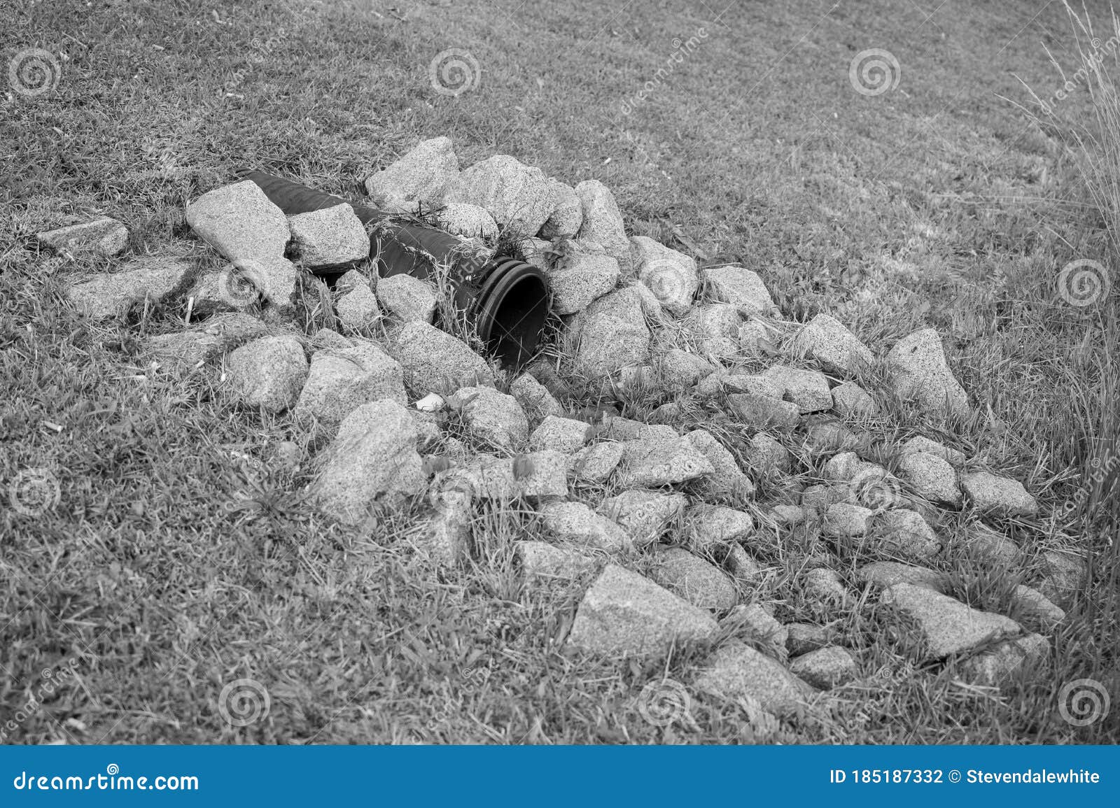 Plastic Storm Water Outlet With Rip-rap Protruding From A Grass ...