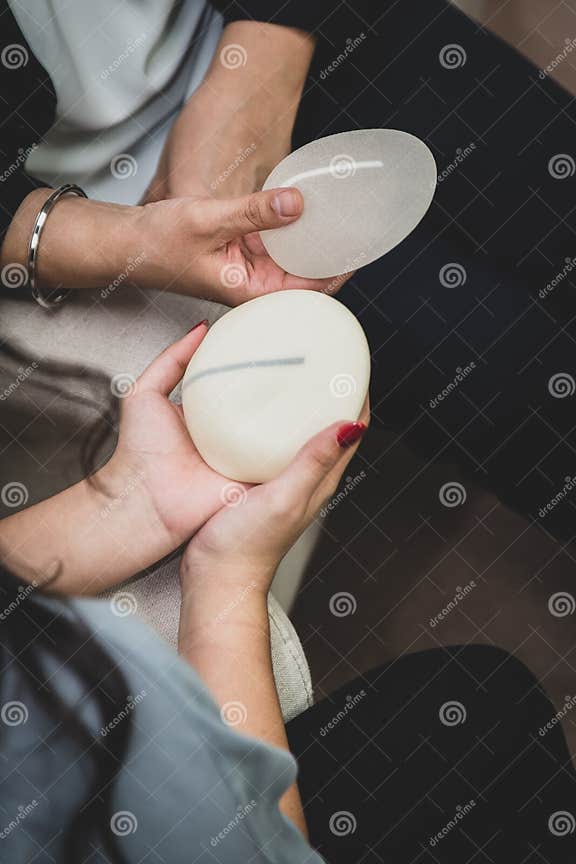Plastic Surgeon And Patient Discuss Choice Of Breast Implants After