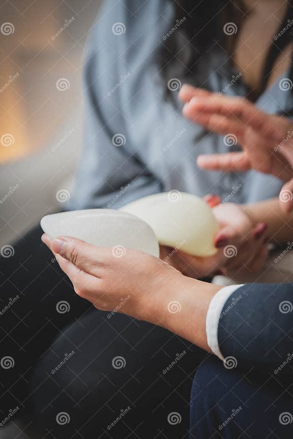 Plastic Surgeon And Patient Discuss Choice Of Breast Implants After