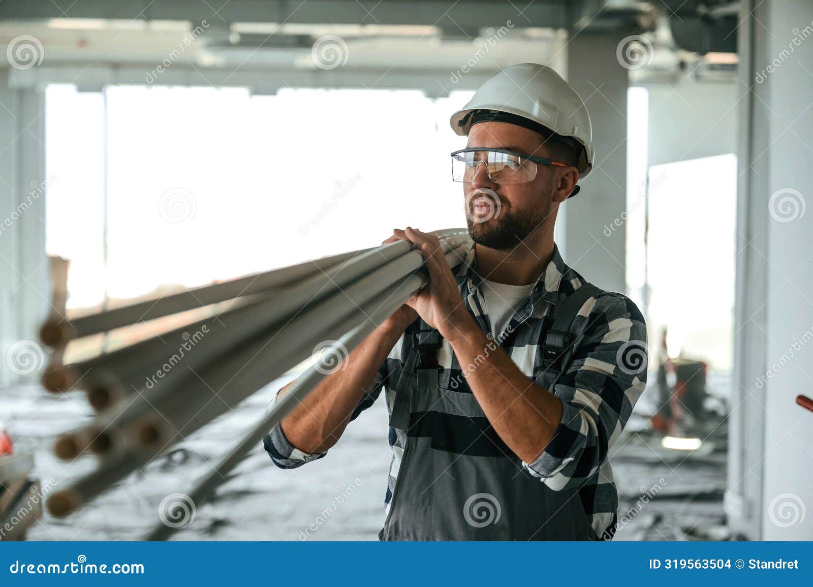 Plastic Tubes in Hands. Construction Worker in Uniform in Empty ...