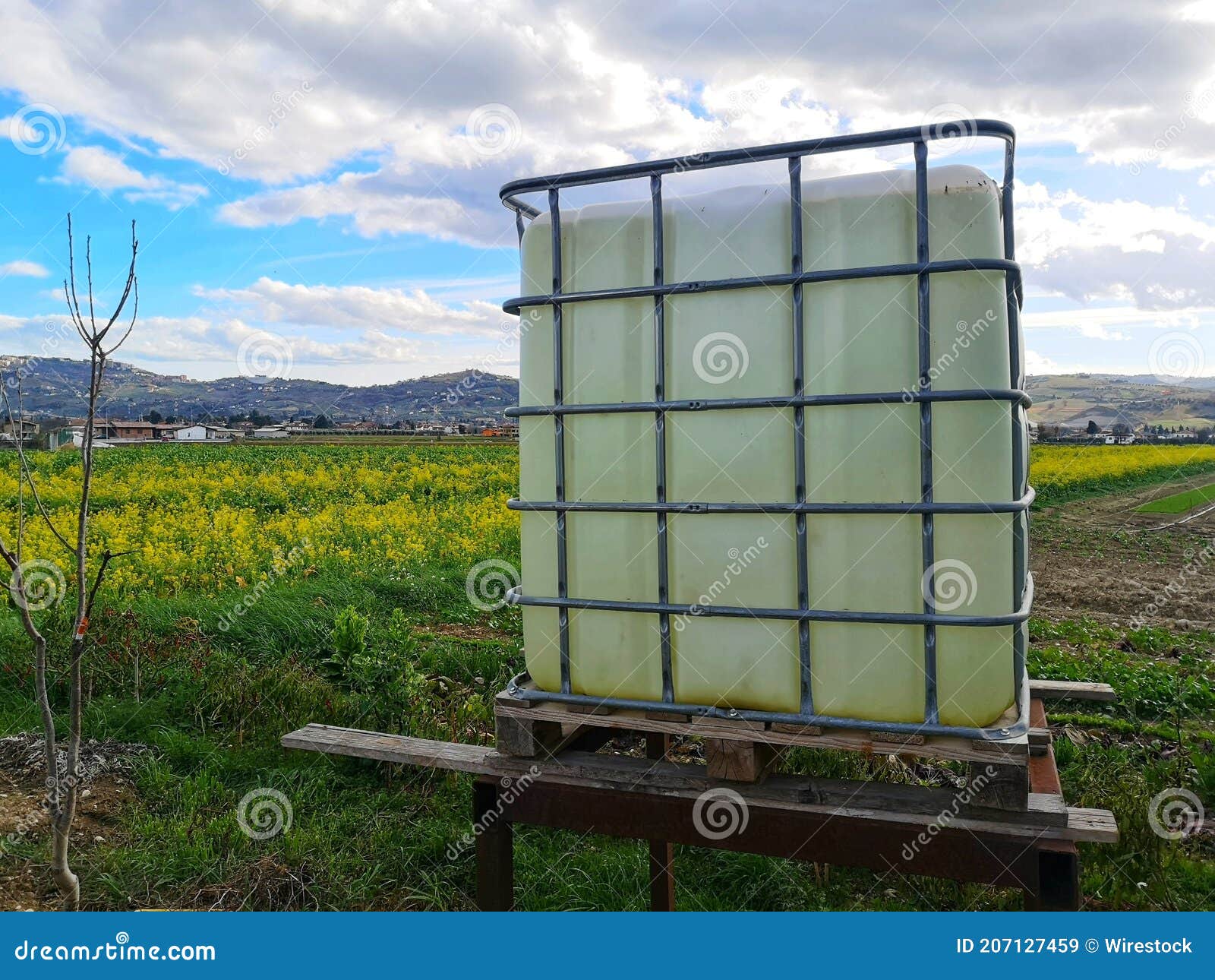 Plastic Water Tank in a Farm Field Under a Blue Cloudy Sky and Sunlight ...