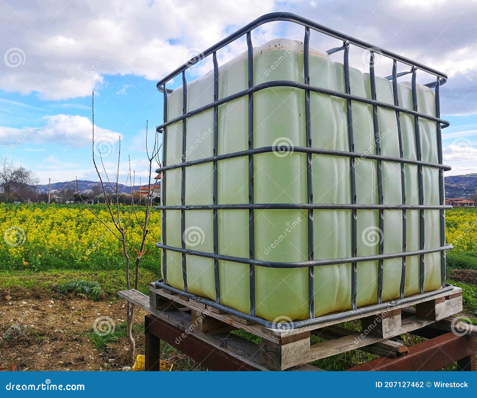 Plastic Water Tank in a Farm Field Under a Blue Cloudy Sky and Sunlight ...