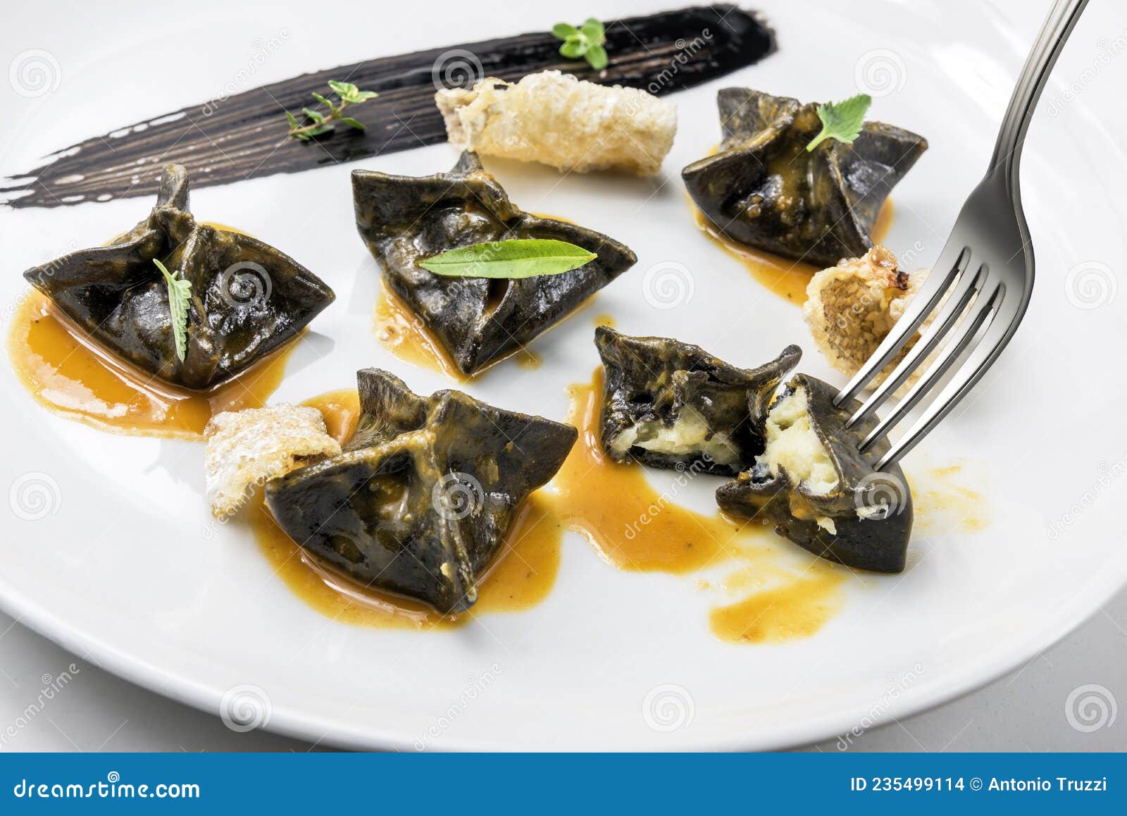 Plate of Black Ravioli Stuffed with Cod with Shellfish Bisque Stock ...