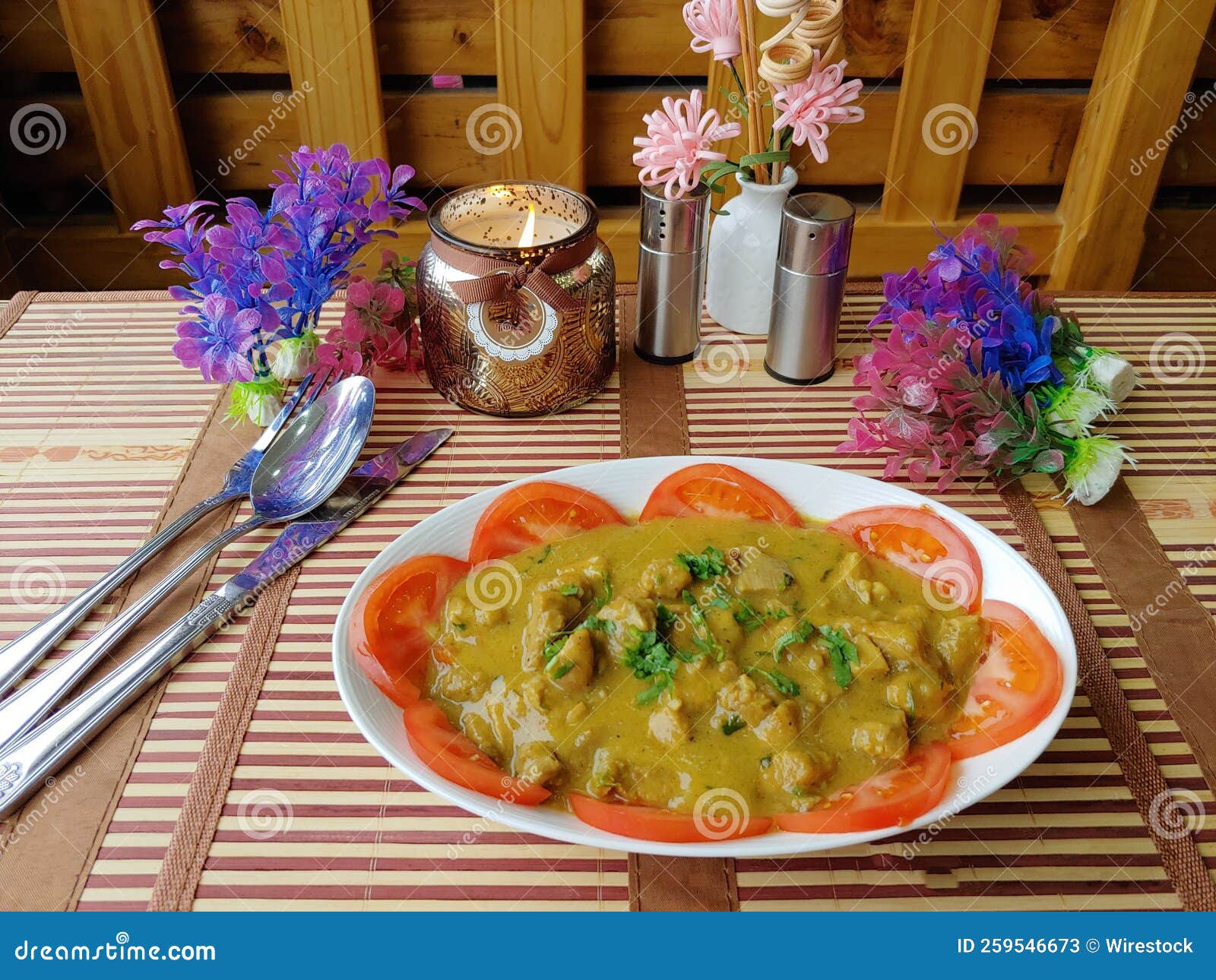 Plate of Chicken Korma Dish on a Dinner Table with Cutlery and Flowers ...