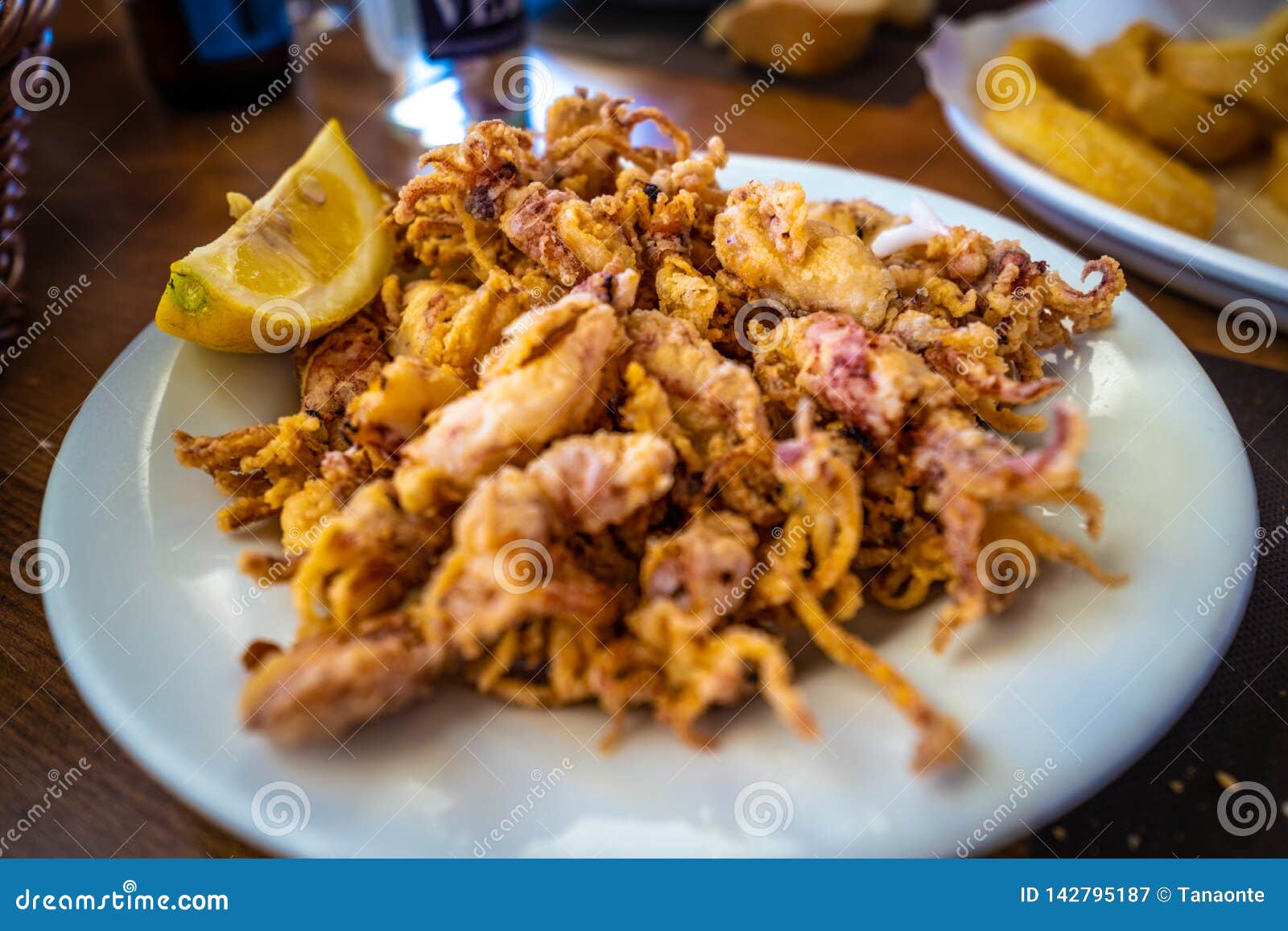 Plate of Deep Fried Squids or Chipirones with Lemon. Typical Spanish ...