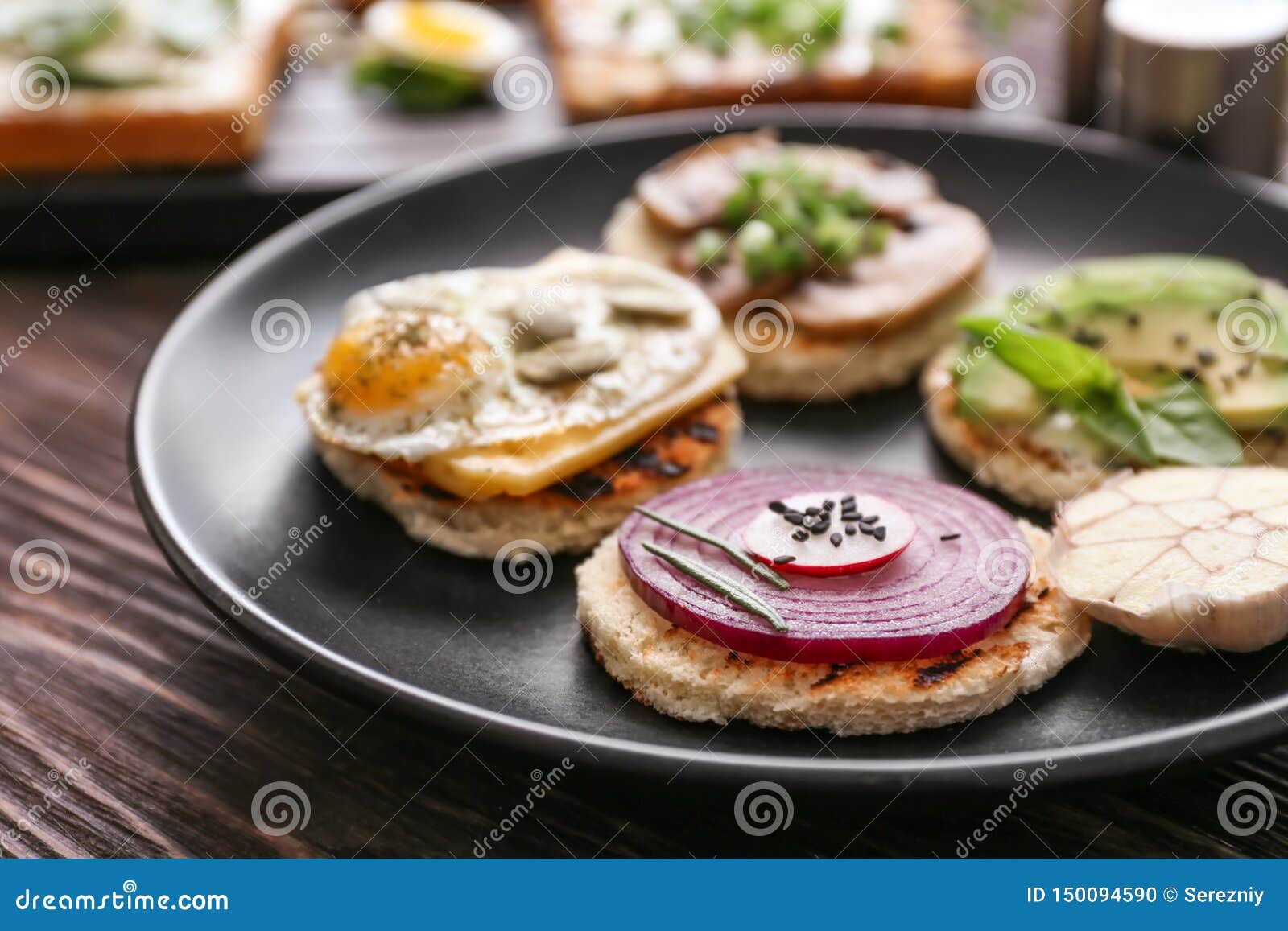 Plate with Different Delicious Toasts on Table, Closeup Stock Photo ...