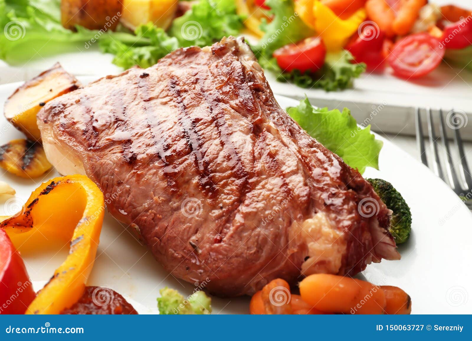 Plate with Meat and Vegetable Garnish on Table, Closeup Stock Image ...
