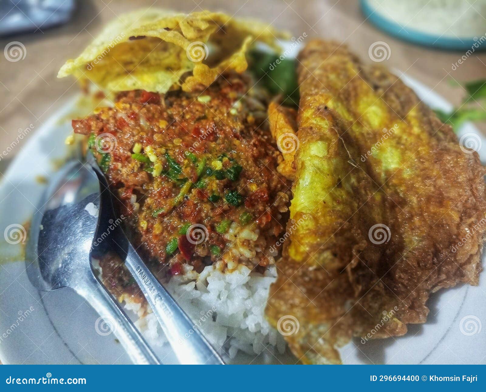 A Plate of Pecel Rice with Peanut Sauce Topped with Peyek and Fried Egg ...