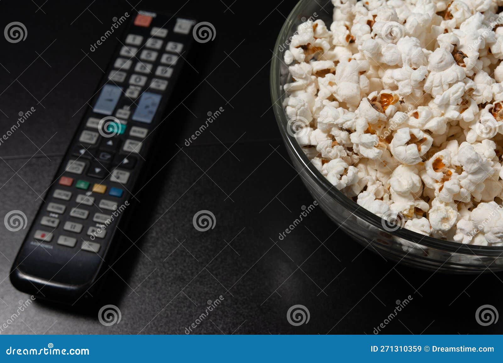 A Plate of Popcorn and a TV Remote on a Black Background. Stock Image ...