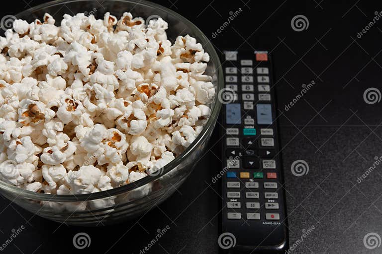 A Plate of Popcorn and a TV Remote on a Black Background. Stock Photo ...