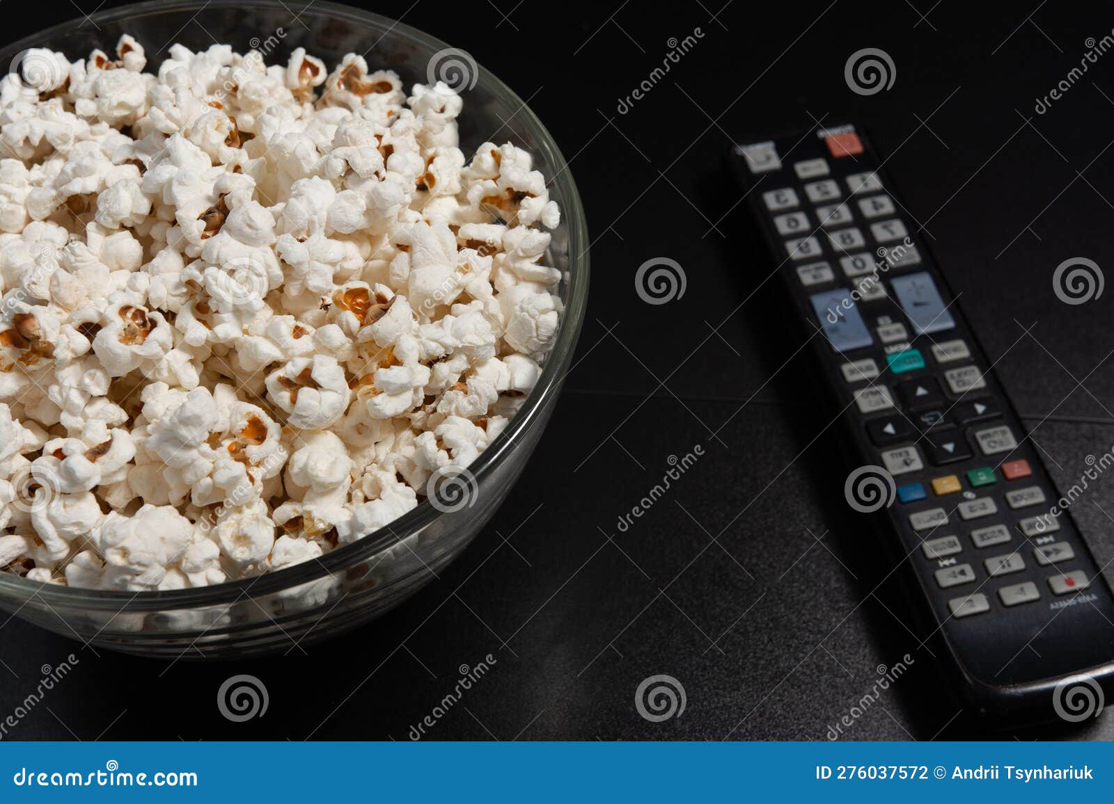 A Plate of Popcorn and a TV Remote on a Black Background. Stock Photo ...