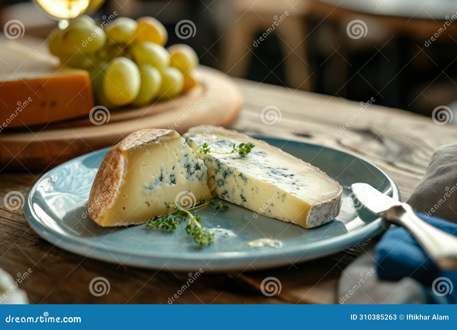 A Plate with a Selection of Cheese and Grapes is Placed on a Table ...