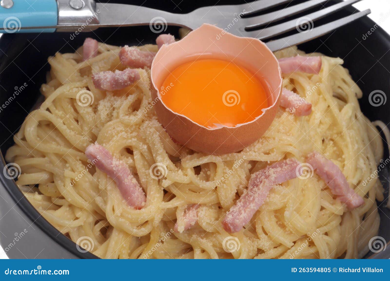Plate Of Spaghetti Carbonara With An Egg Yolk And A Fork Close Up Stock