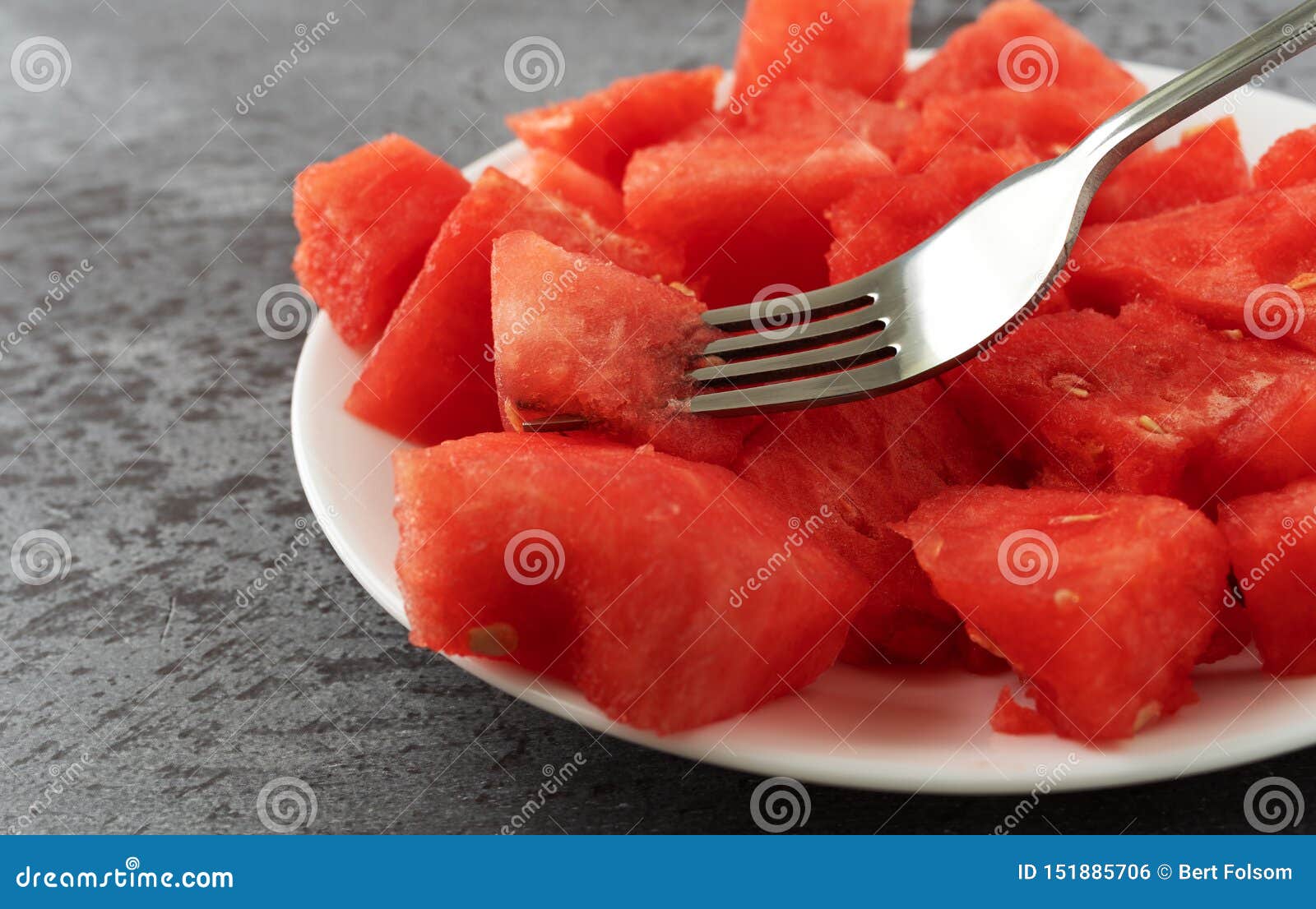 Plate of Watermelon Chunks with a Fork on a Gray Mottled Table Side ...