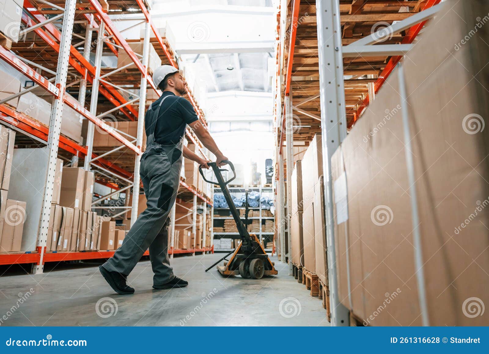 With Platform Trolley. Employee in Uniform is Working in the Storage at ...