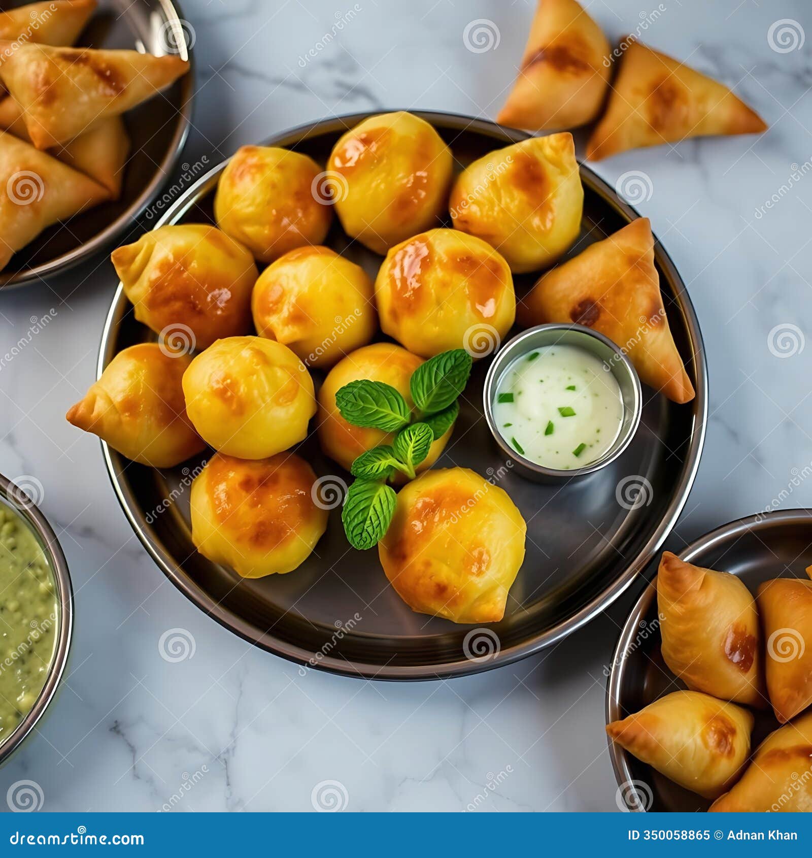A Platter of Dahi Vada, Samosas, and a Side of Mint Chutney on a Table ...