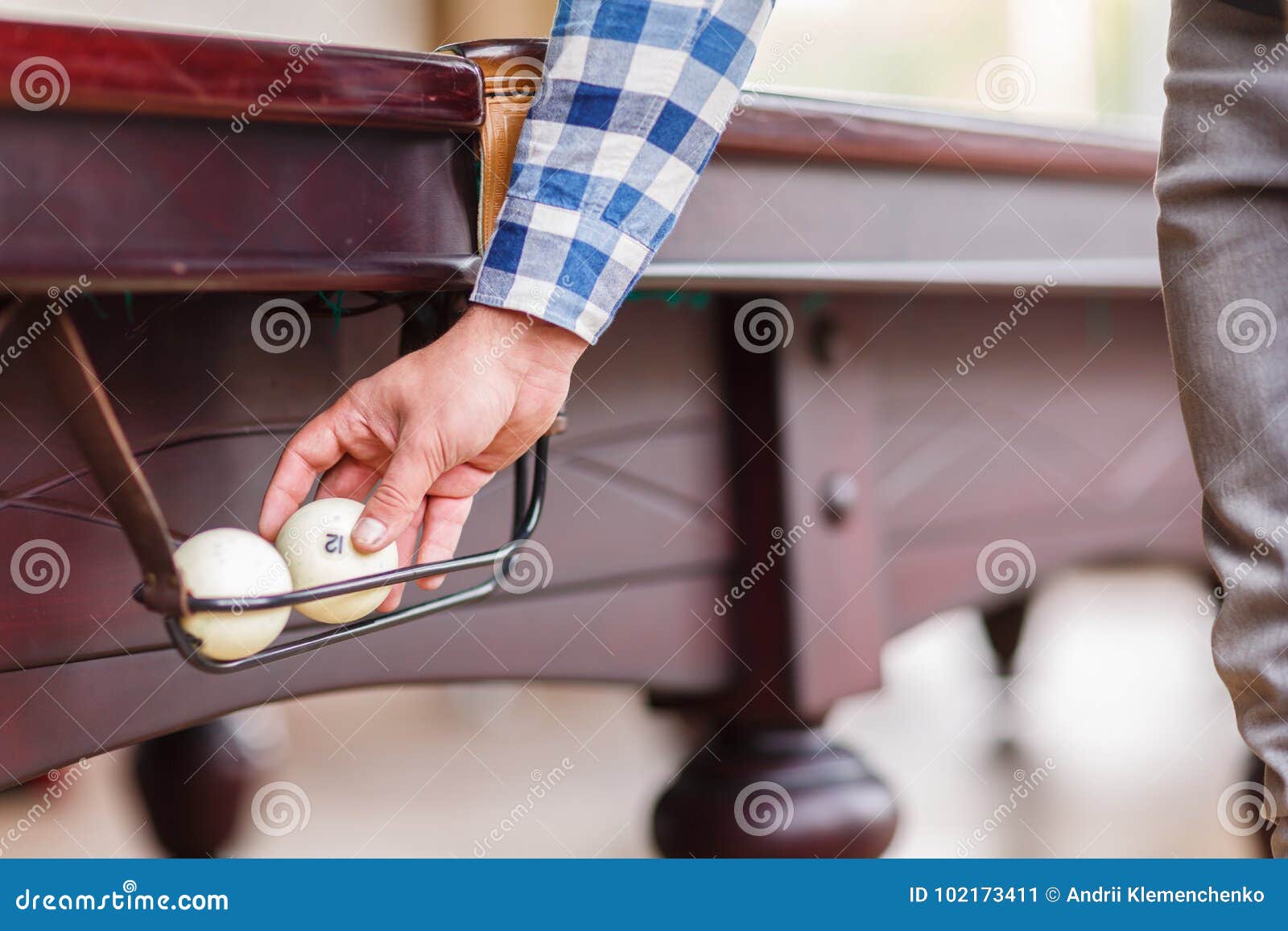 The Player Pulls Out the Billiard Ball from the Pocket of the Table ...