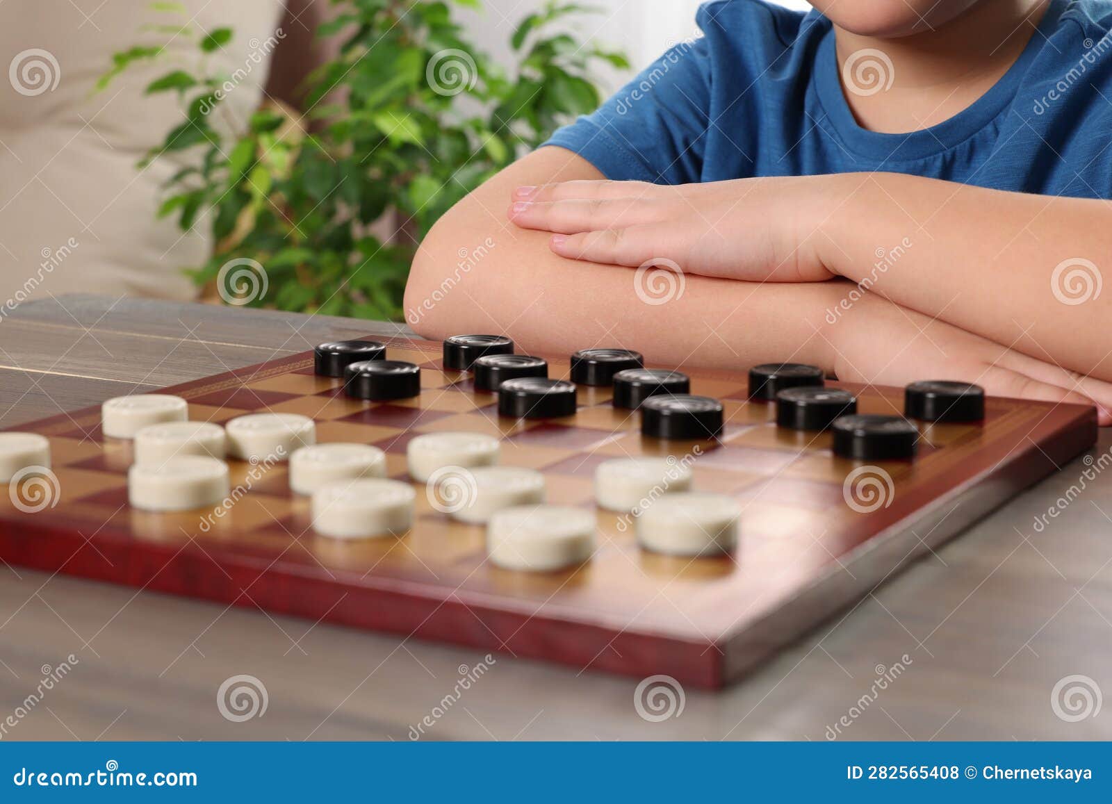 Playing Checkers. Boy Thinking about Next Move at Table in Room Stock ...