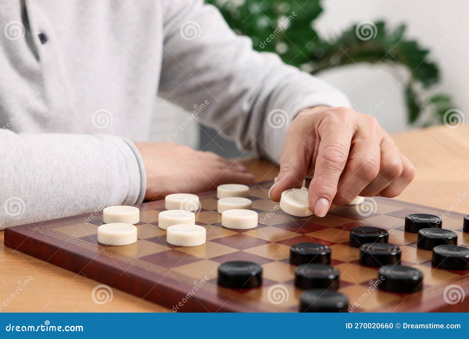 Playing Checkers. Senior Man Thinking about Next Move at Table in Room ...