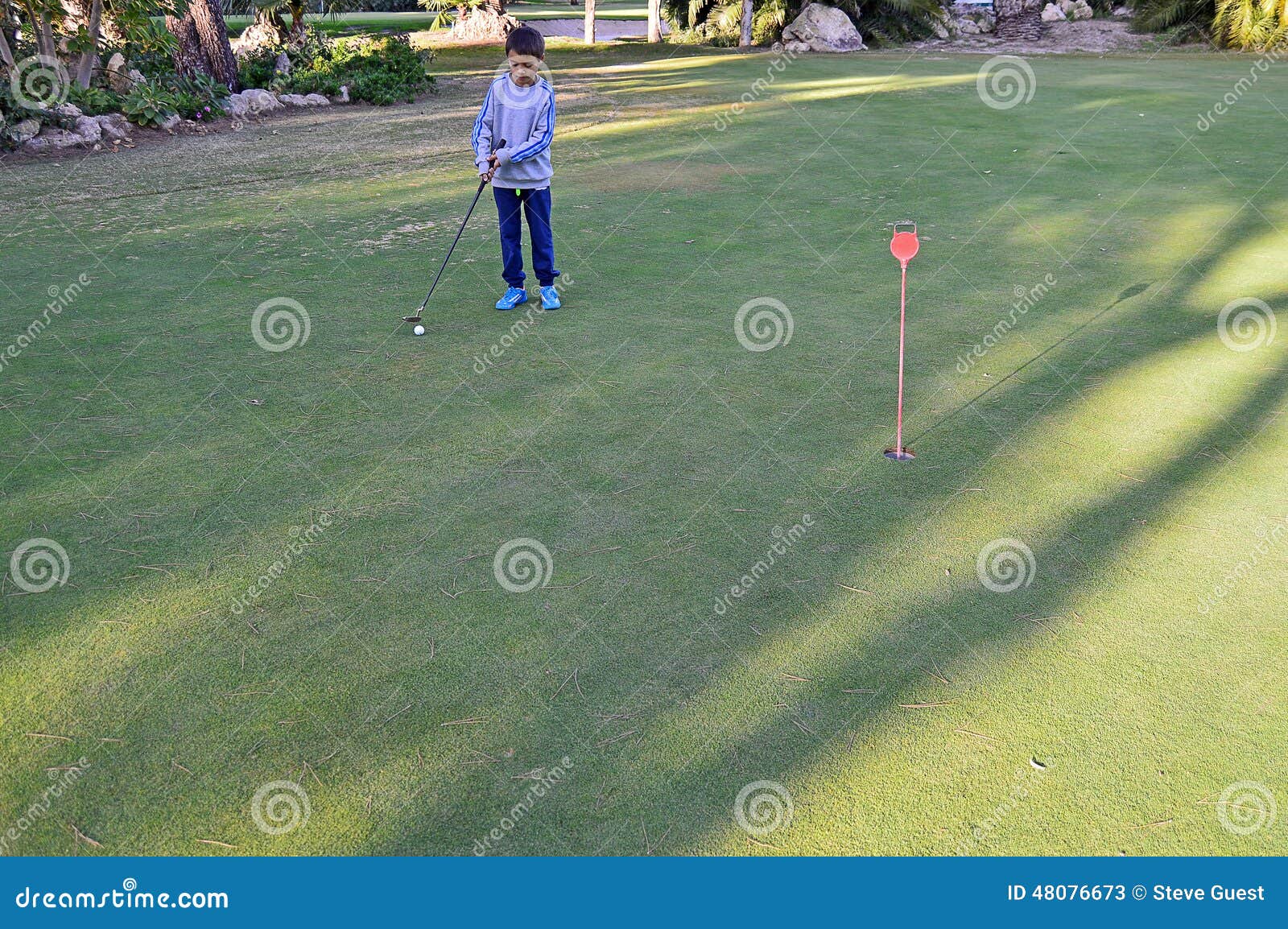 Playing Golf - a Boy Putting with Oversize Putter. Stock Image - Image ...