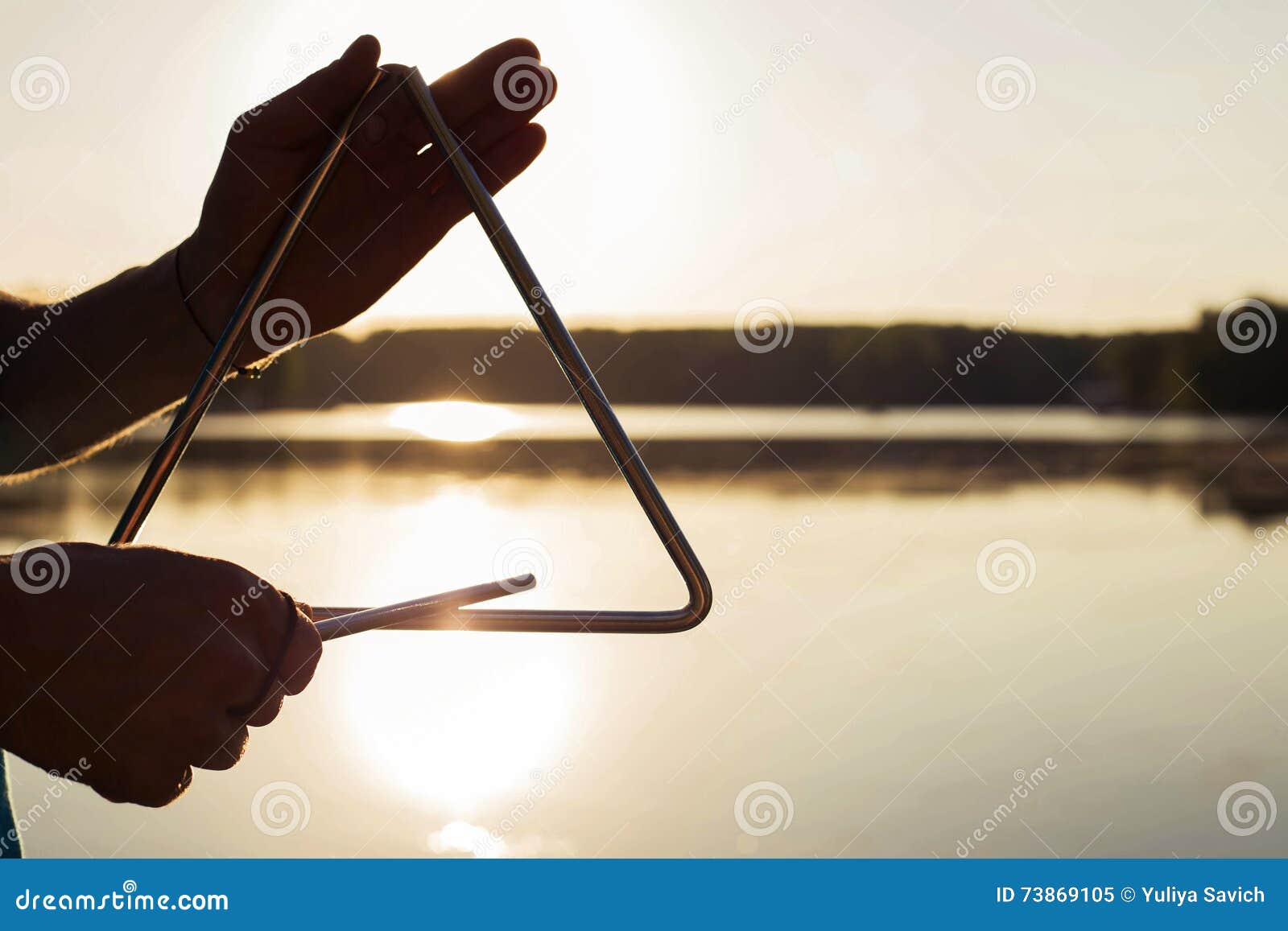 Playing a Musical Instrument Triangle on Background Sky at Sunset Stock ...