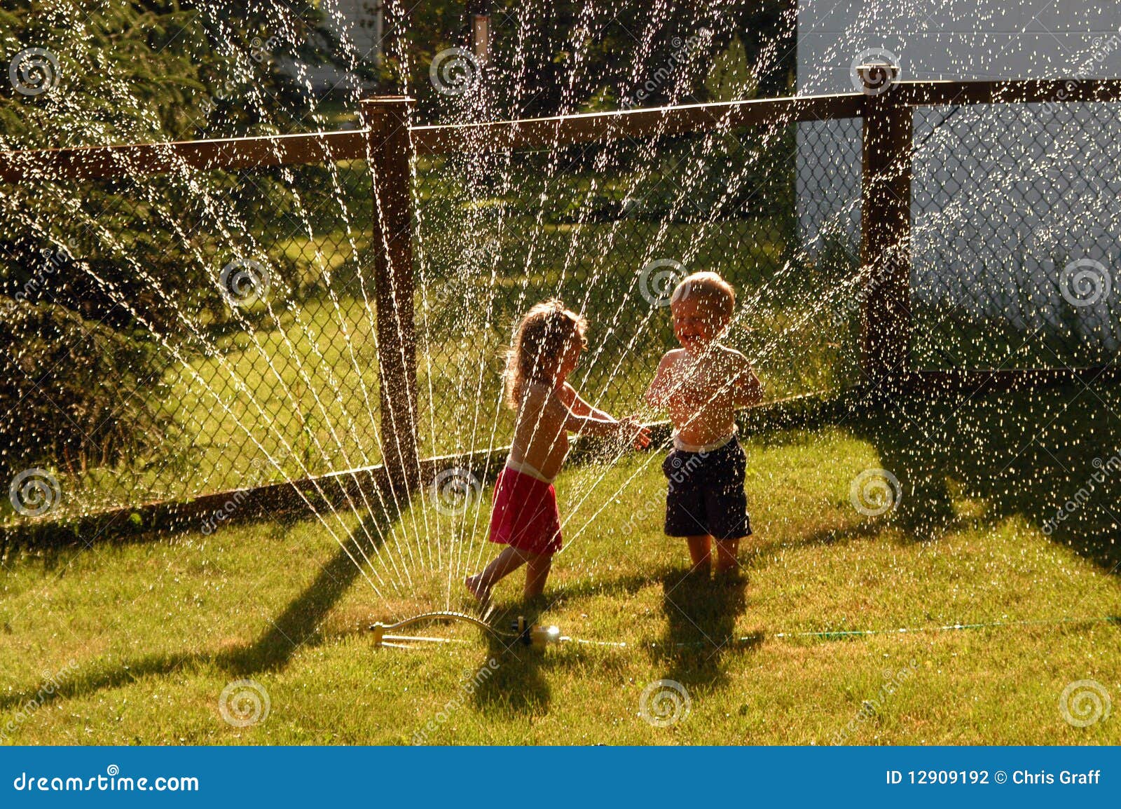 Playing in a Sprinkler stock photo. Image of friend, hose - 12909192