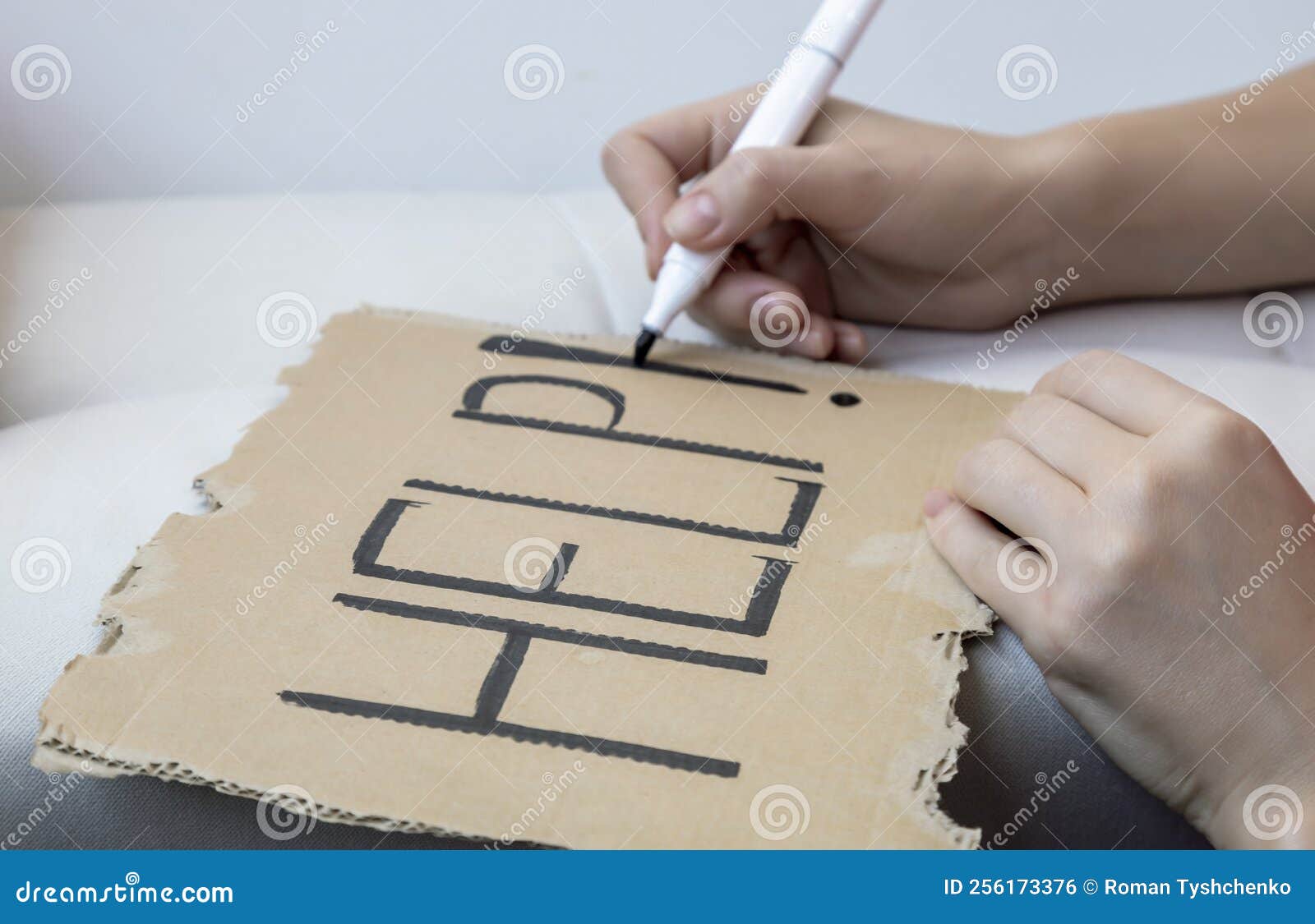A Plea for Help. a Woman Writes the Word Help on a Sheet of Cardboard ...