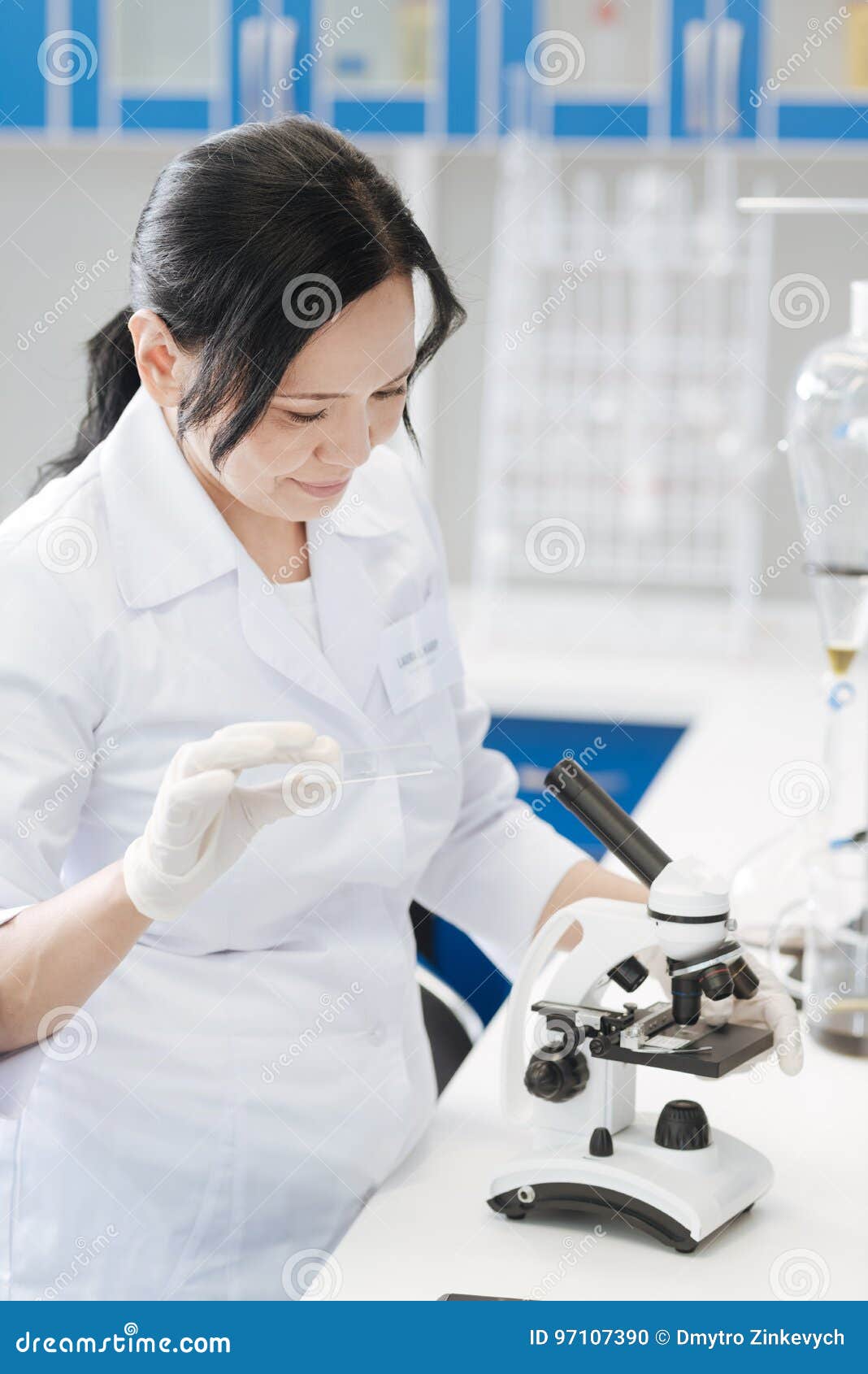 Pleasant Professional Biologist Holding a Microscope Slide Stock Photo ...