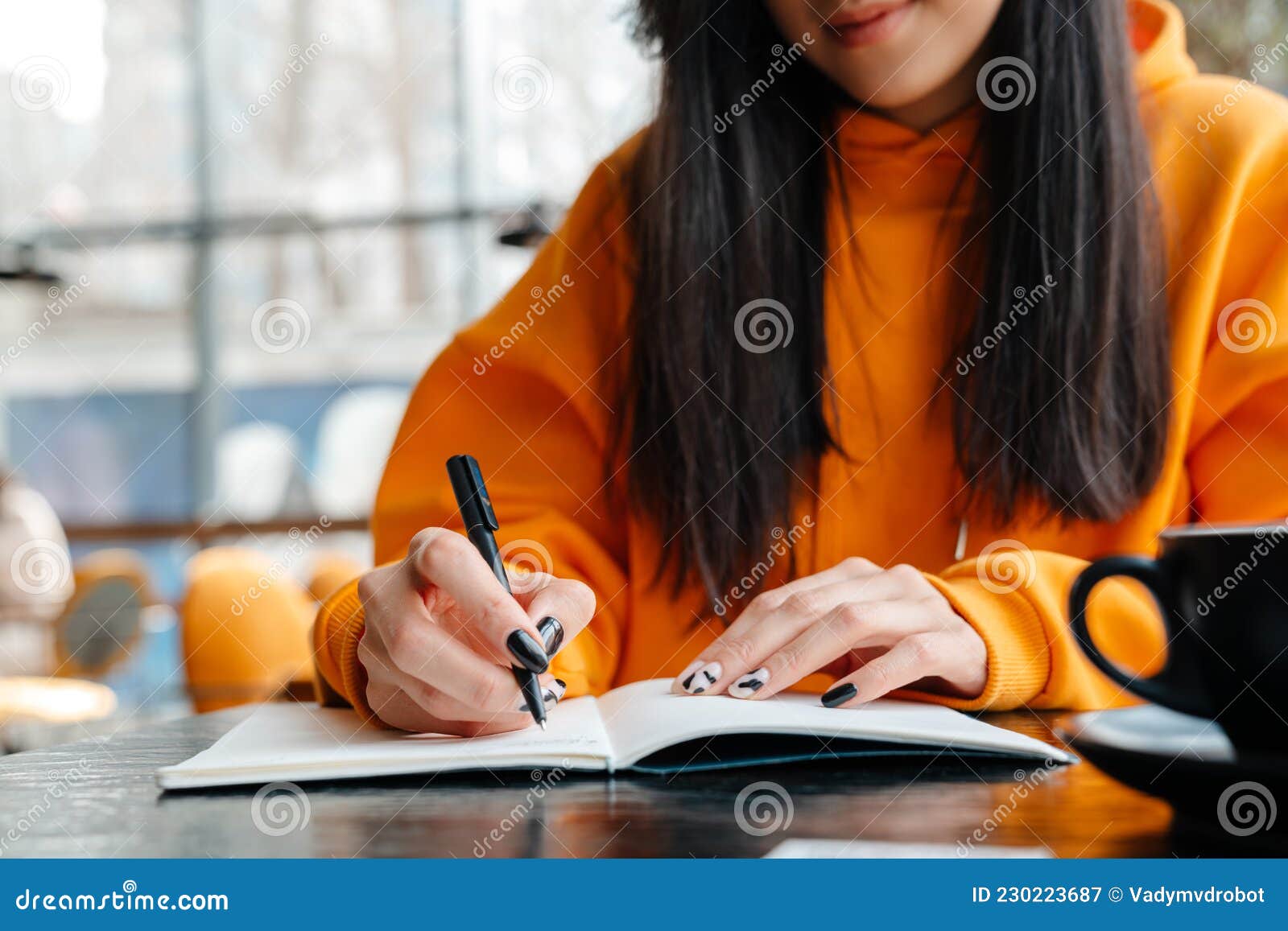 Pleased Asian Woman Writing Down Notes while Sitting Stock Image ...