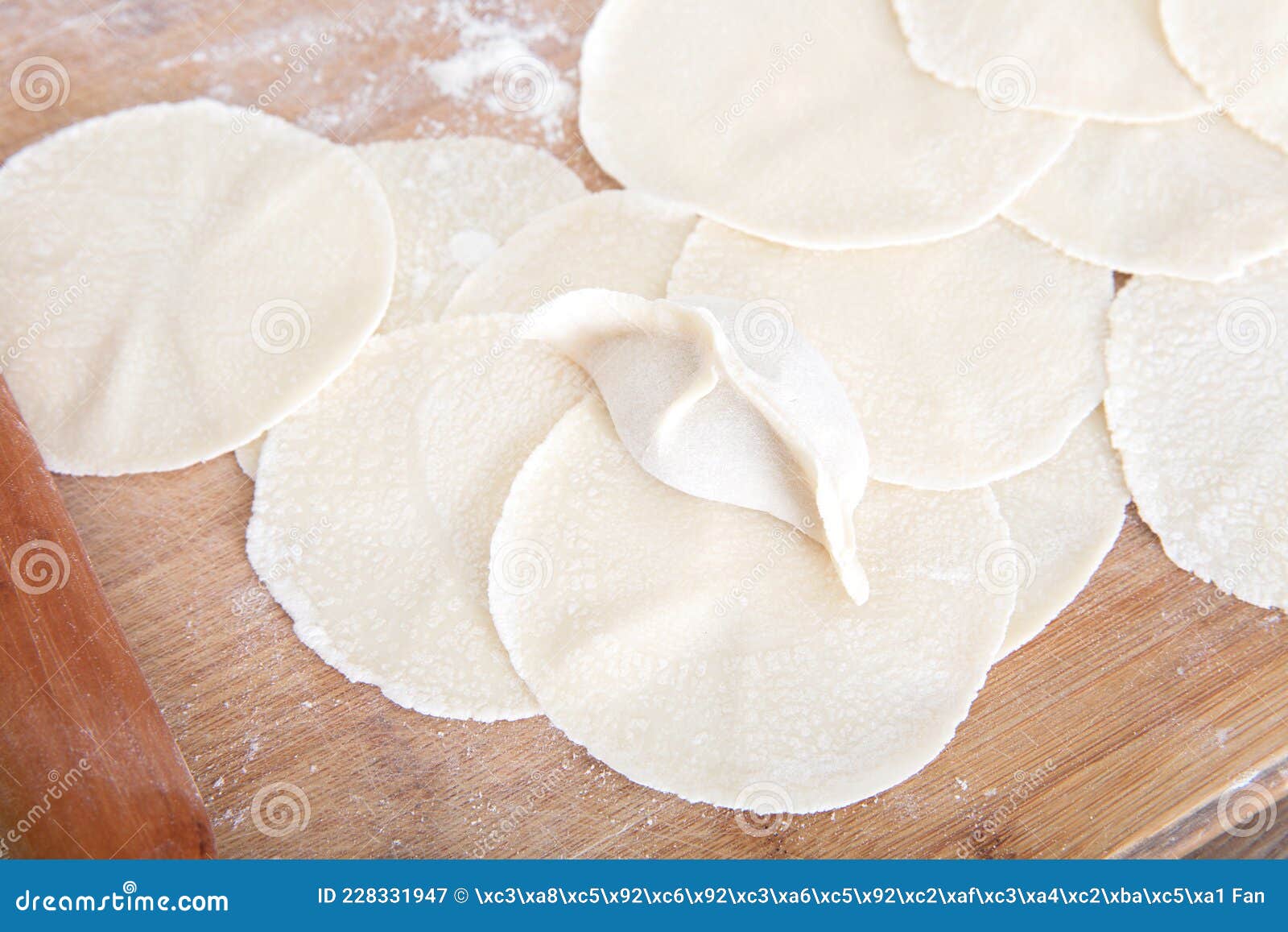Plenty of Dumpling Skins and One Wrapped Dumpling on the Cutting Board ...