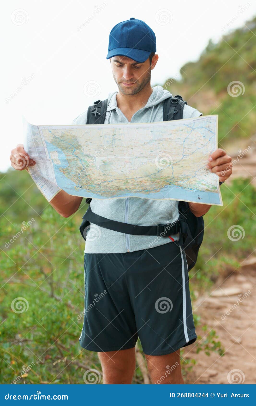 Plotting His Next Move. Handsome Young Hiker Reading a Map while ...