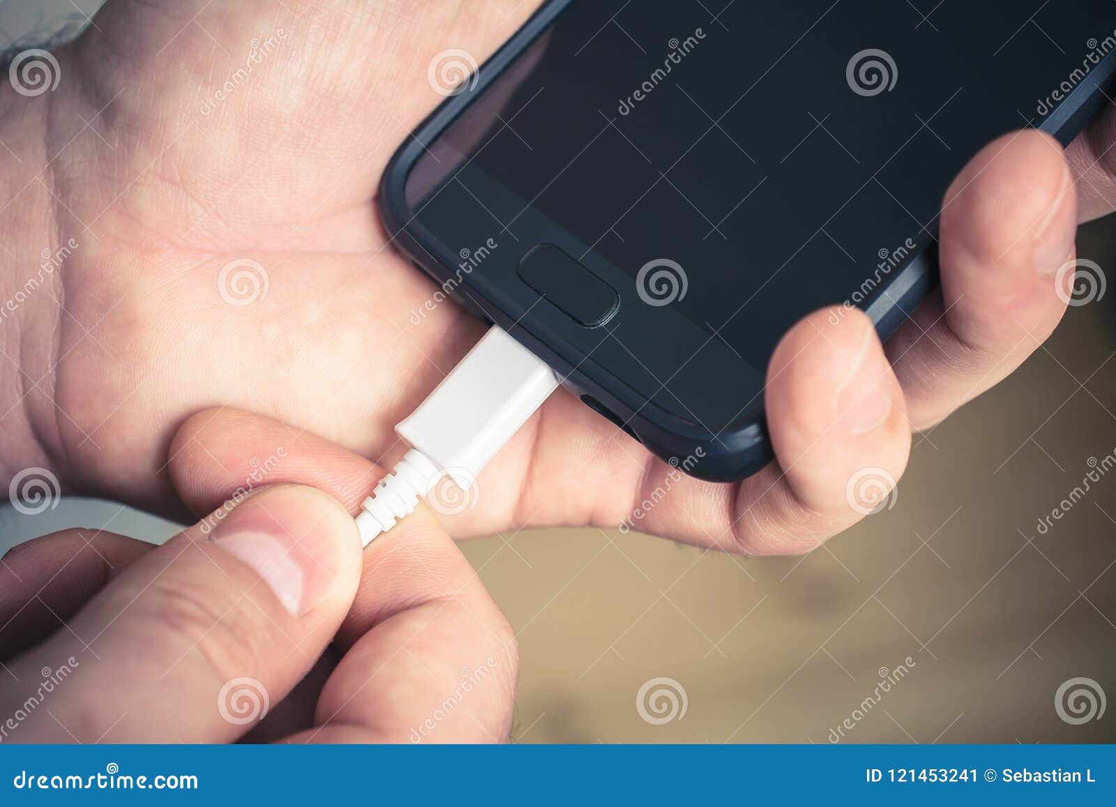 Plugging Out a White USB Cable Connected with a Black Mobile Phone ...
