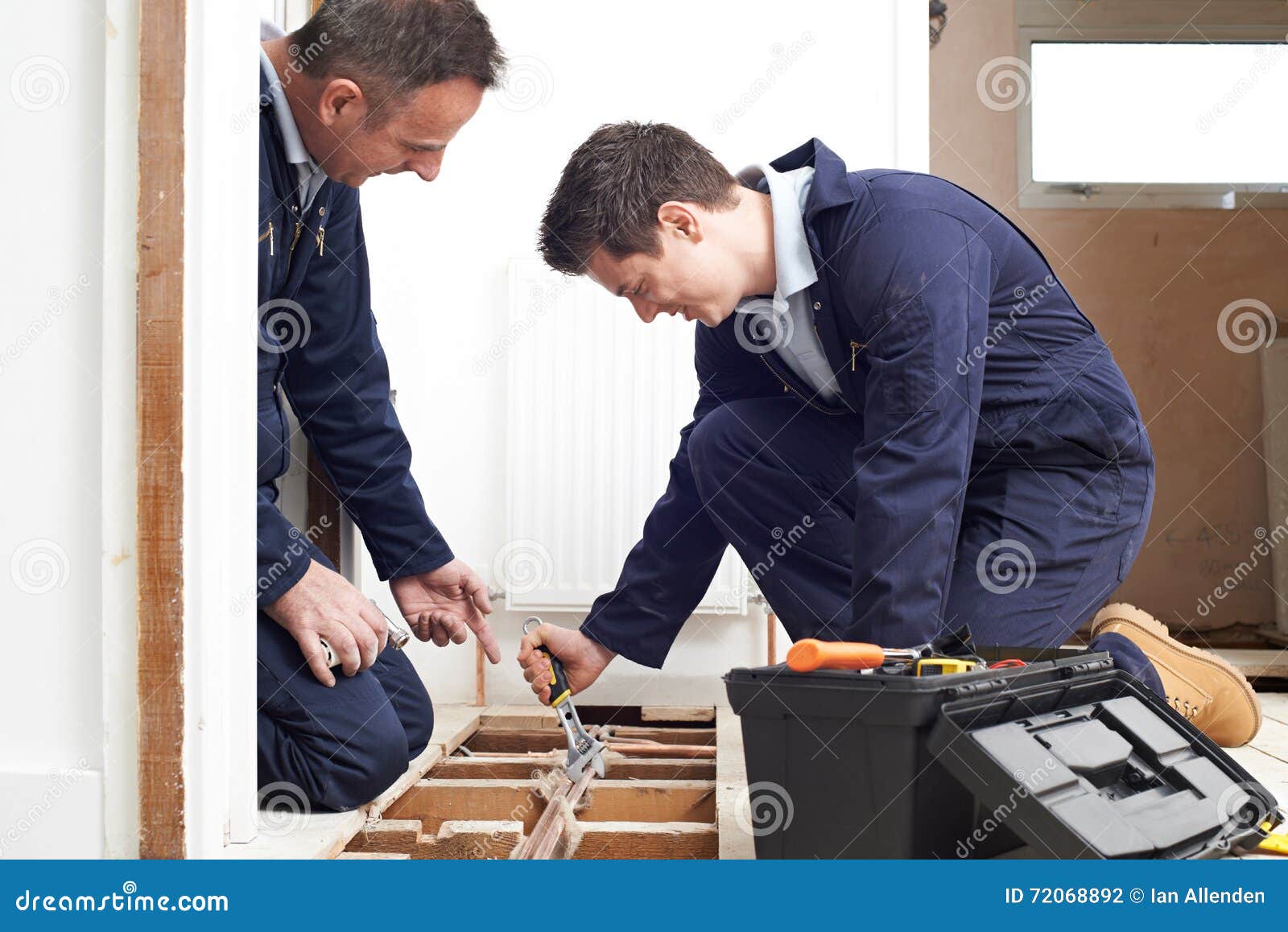 Plumber and Apprentice Fitting Central Heating in House Stock Photo ...