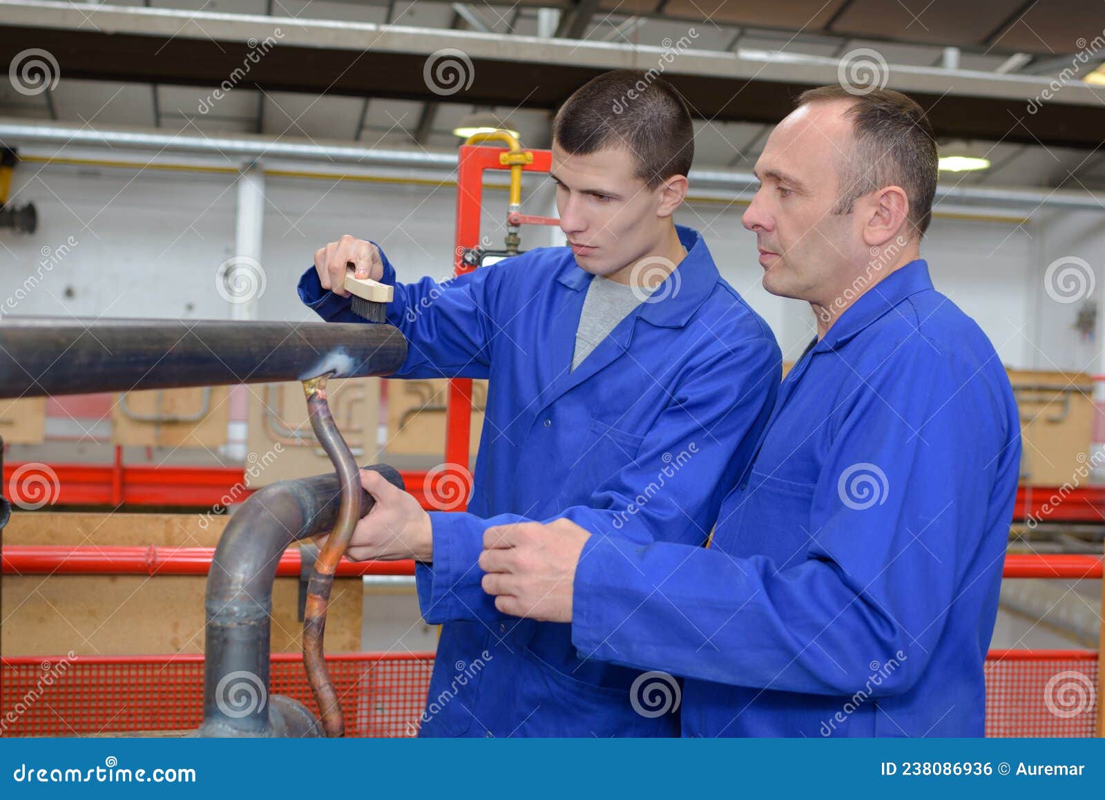 Plumber and Apprentice Fitting Pipes in Warehouse Stock Photo - Image ...