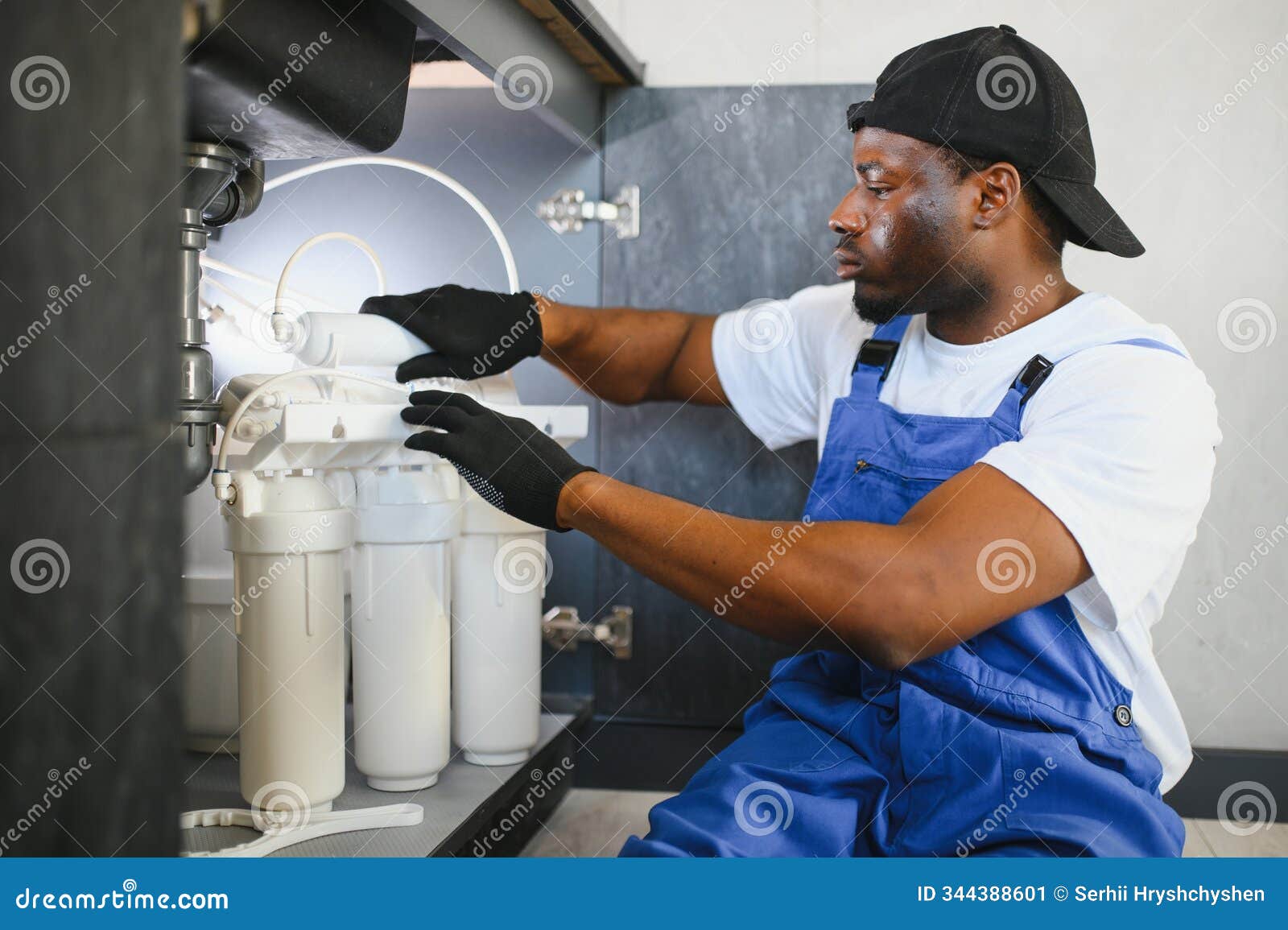 African American Plumber Change the Water Filter. Stock Image - Image ...