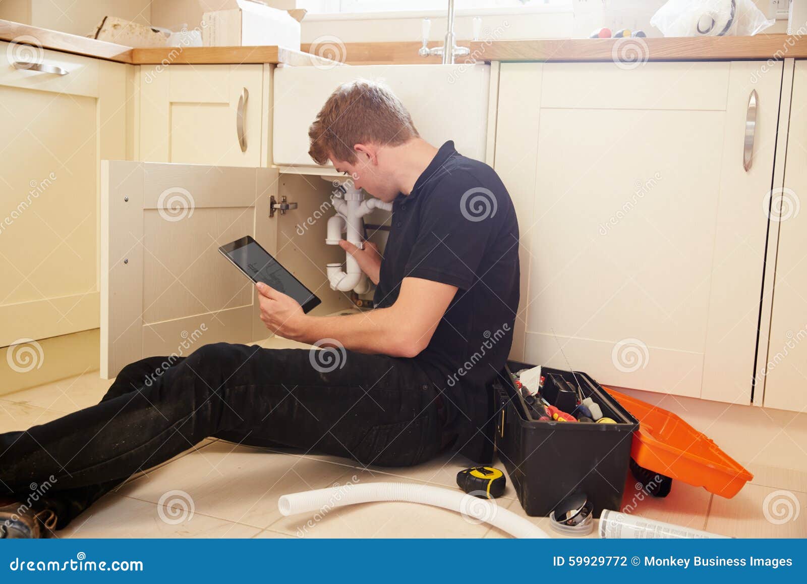 Plumber Fixing Sink in Kitchen Consulting Tablet Computer Stock Photo ...