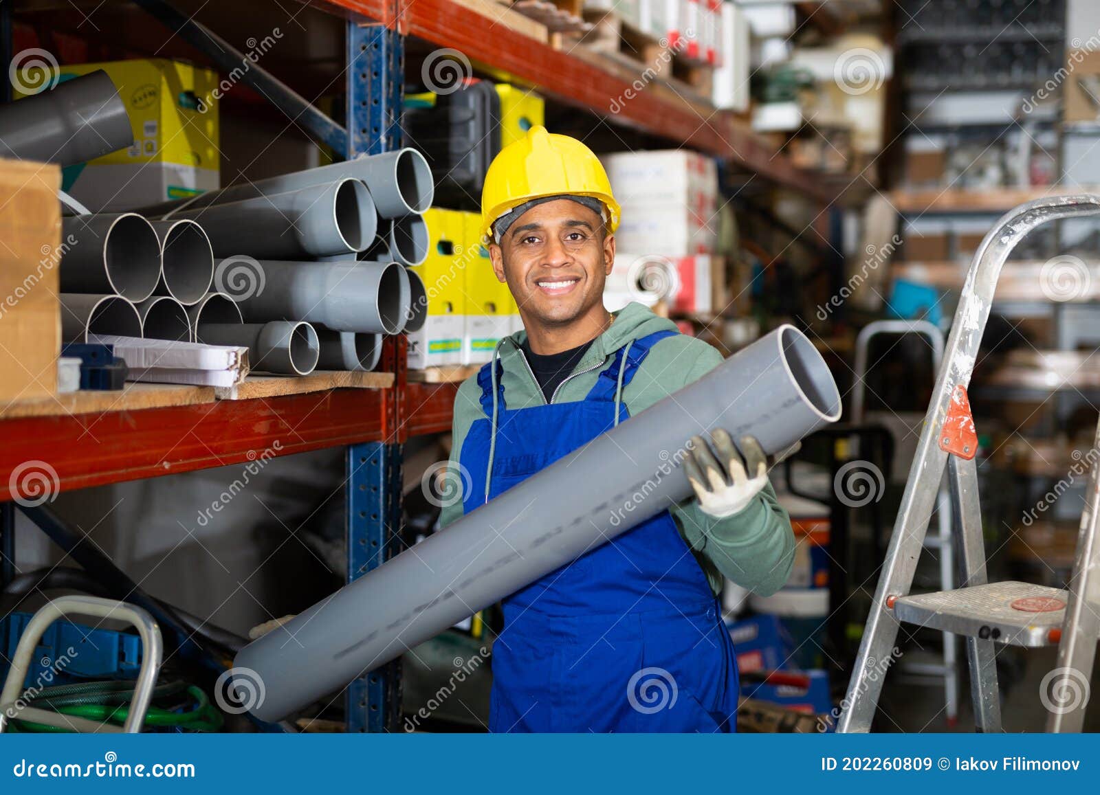 Plumber in Protective Helmet and Overalls Selects Plastic Pipes in ...