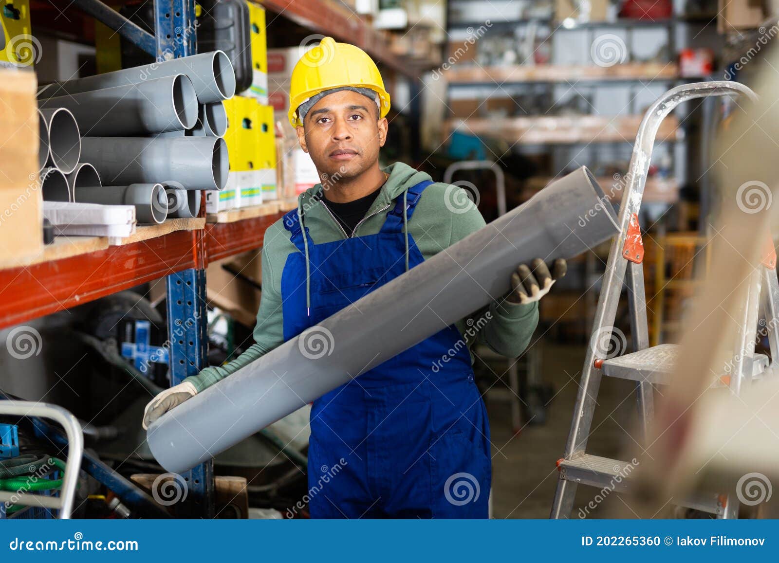 Plumber in Protective Helmet and Overalls Selects Plastic Pipes in ...