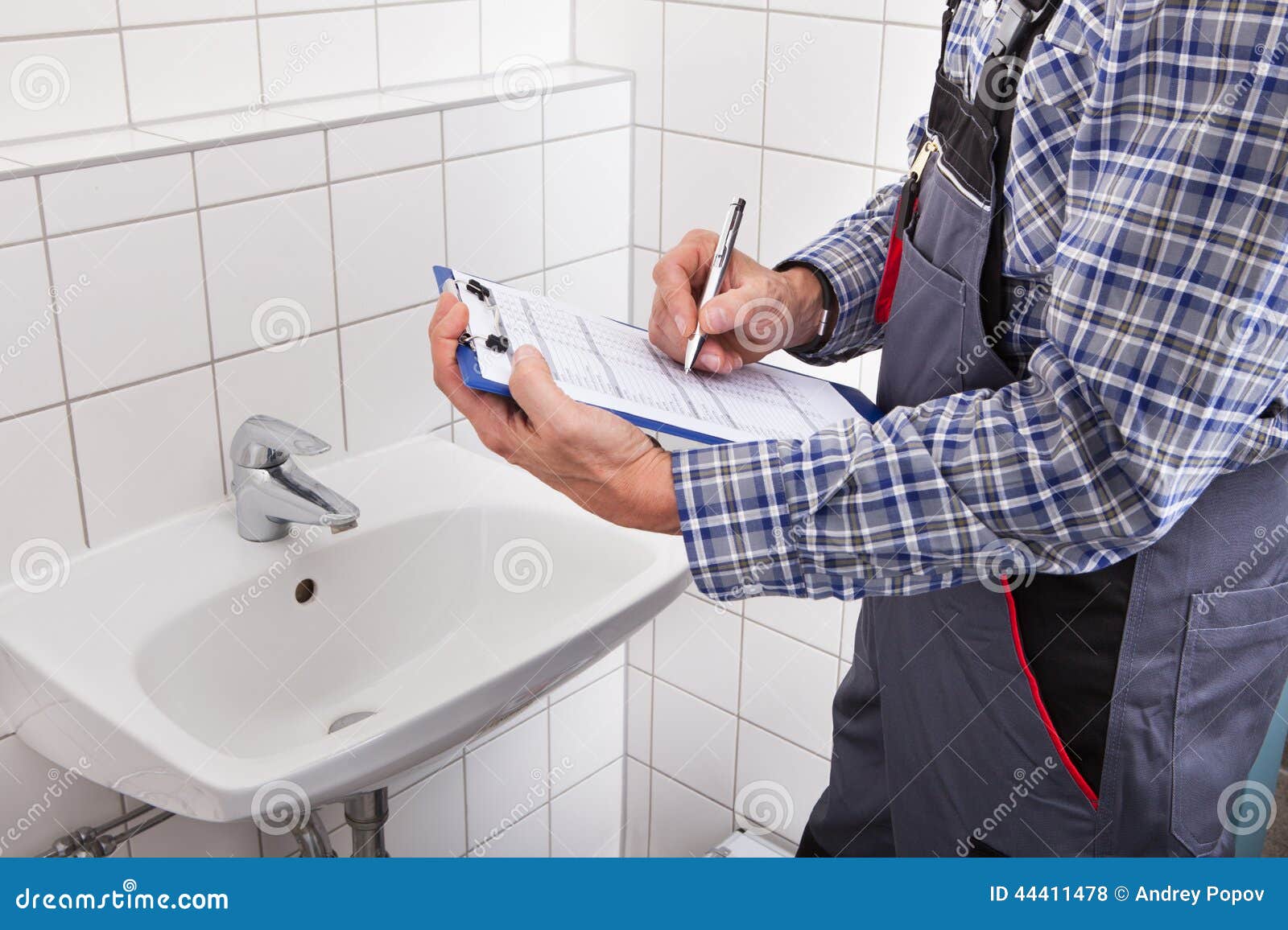 Plumber Standing in Front of Washbasin Writing on Clipboard Stock Photo ...