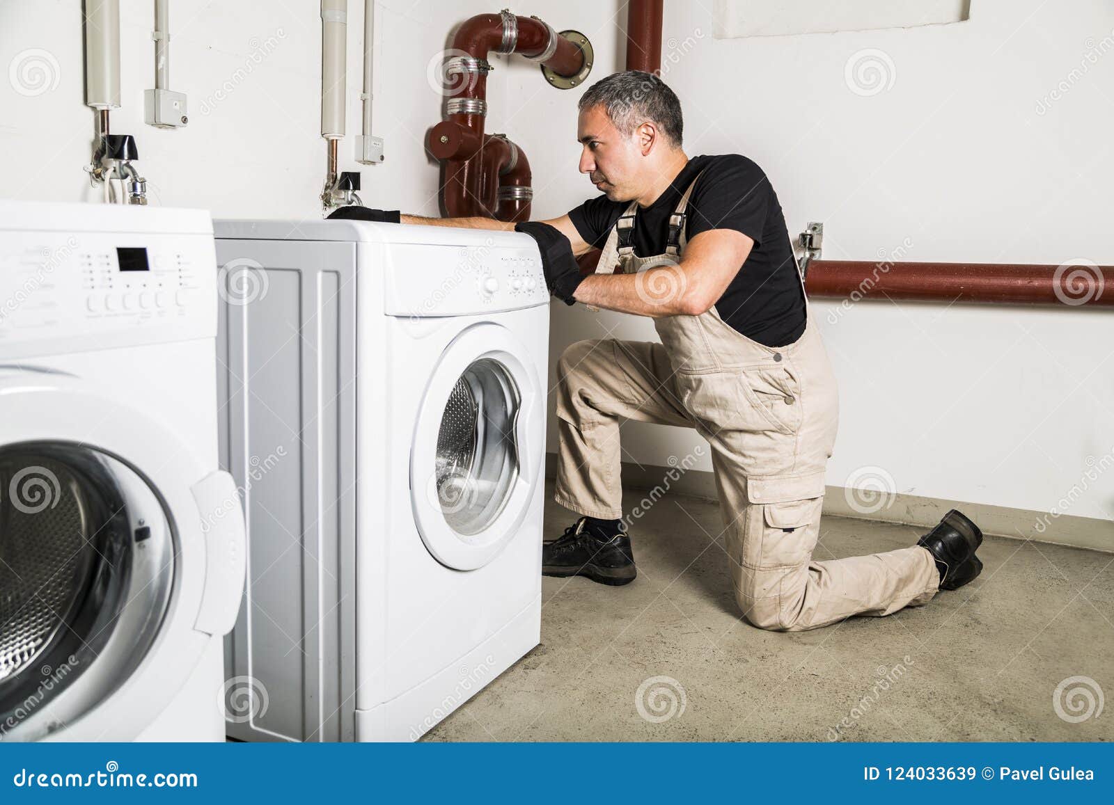 Plumber in Uniform Repairs Inside Washing Machine in Laundry Stock ...