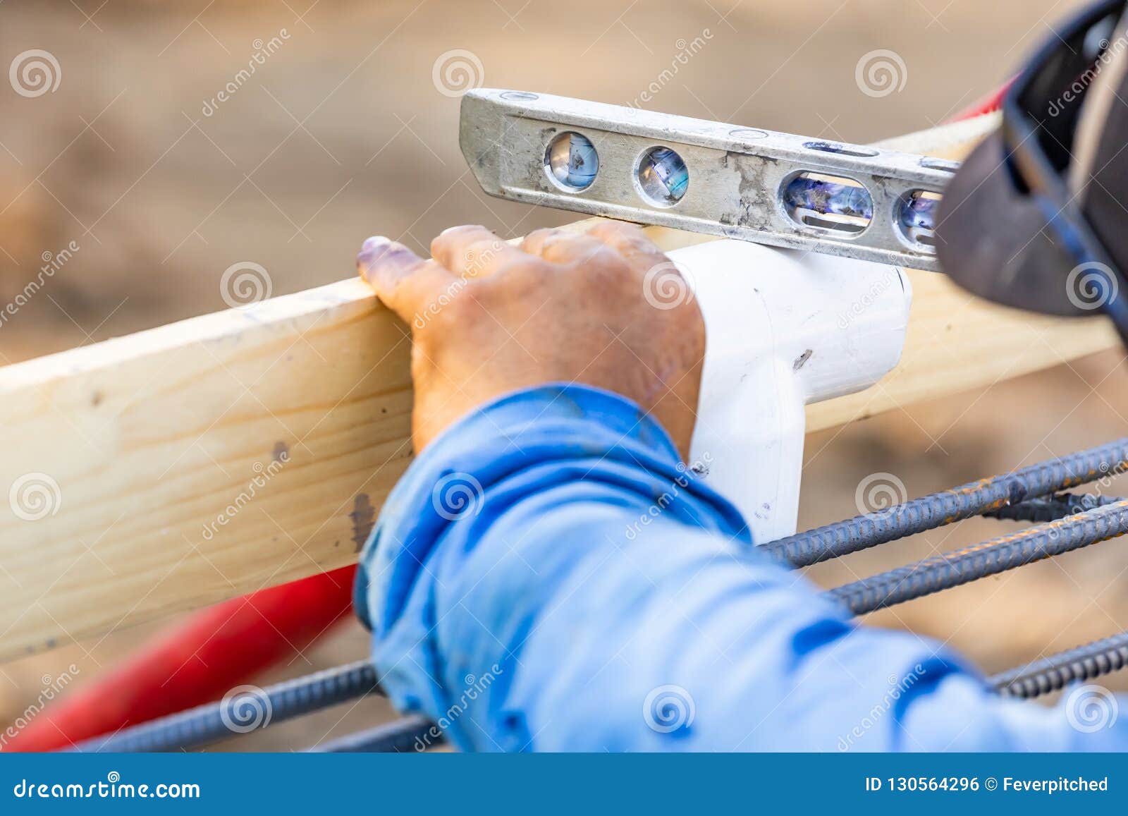 Plumber Using Level while Installing PVC Pipe at Construction Site ...