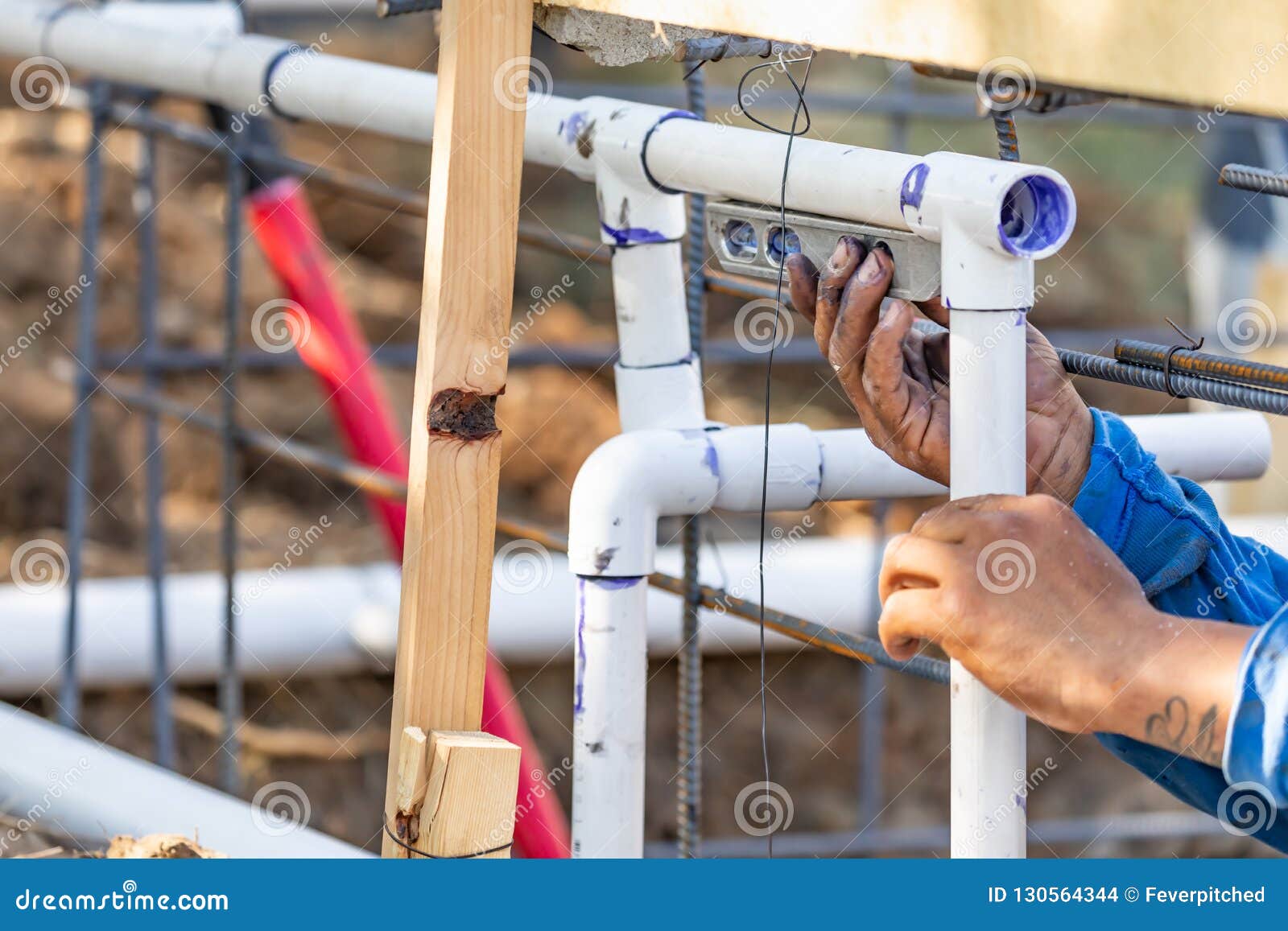 Plumber Using Level while Installing PVC Pipe at Construction Site ...