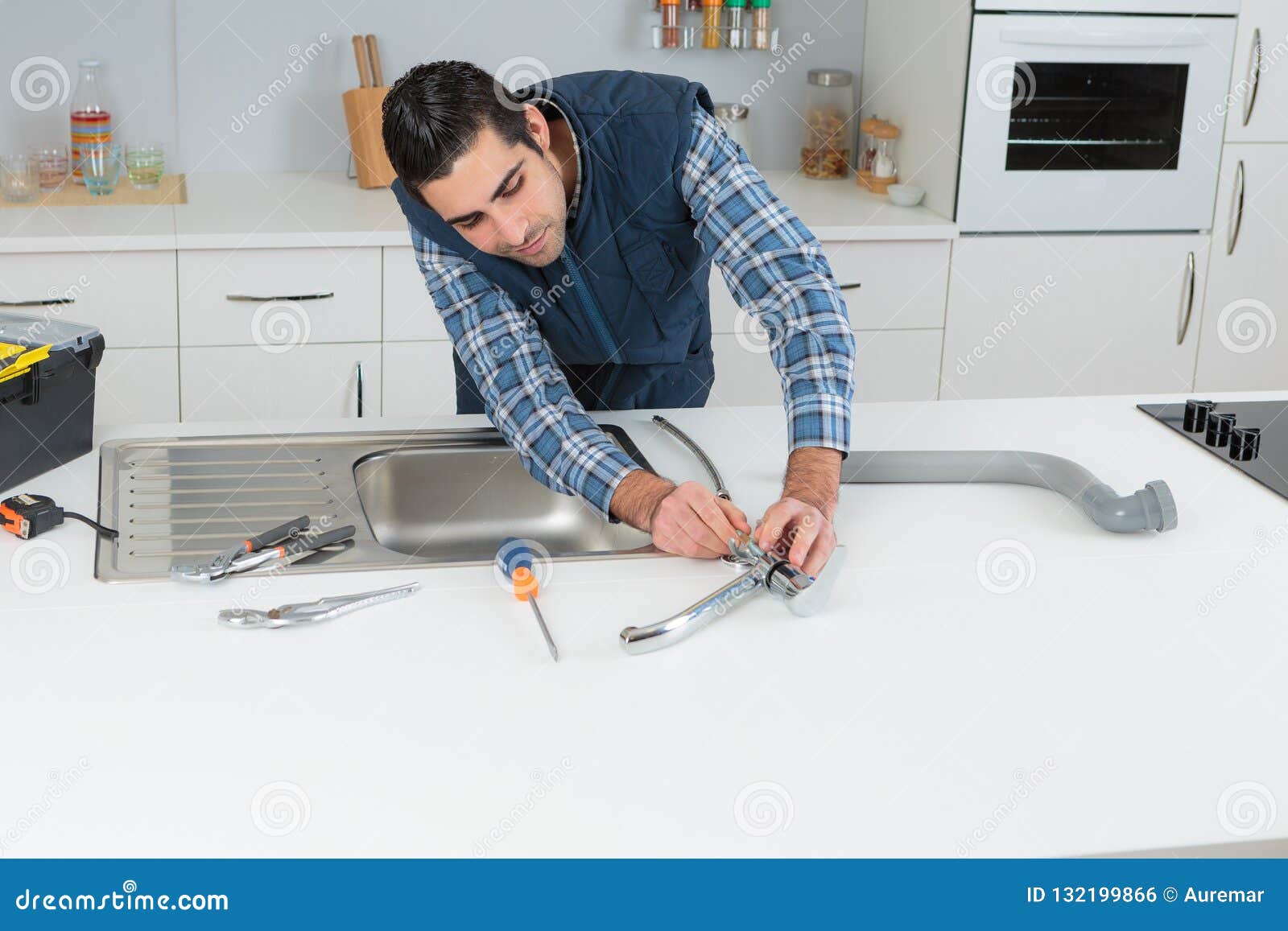 Plumber at work in kitchen stock photo. Image of maintenance - 132199866