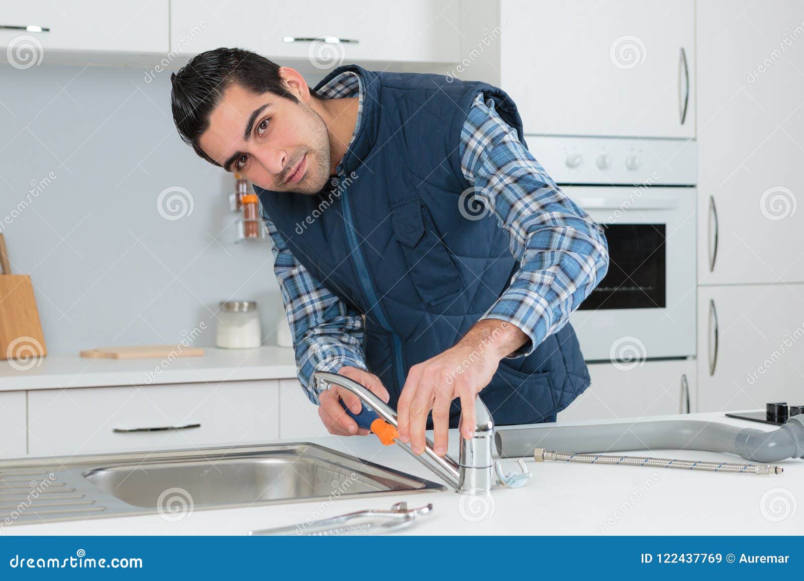 Plumber Working on Tap in Kitchen Stock Image - Image of ethnicity ...
