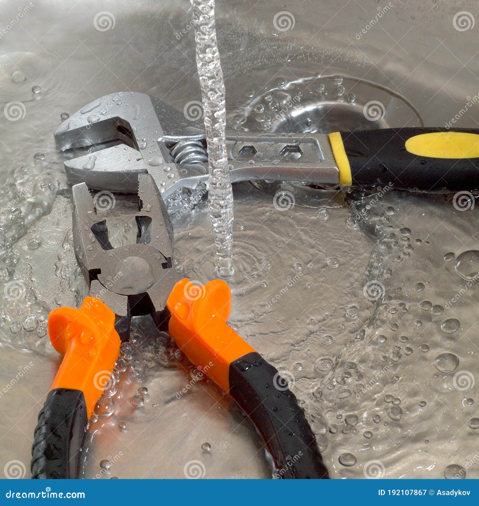 Plumbing Tools Adjustable Wrench and Pliers in a Sink Under Running ...
