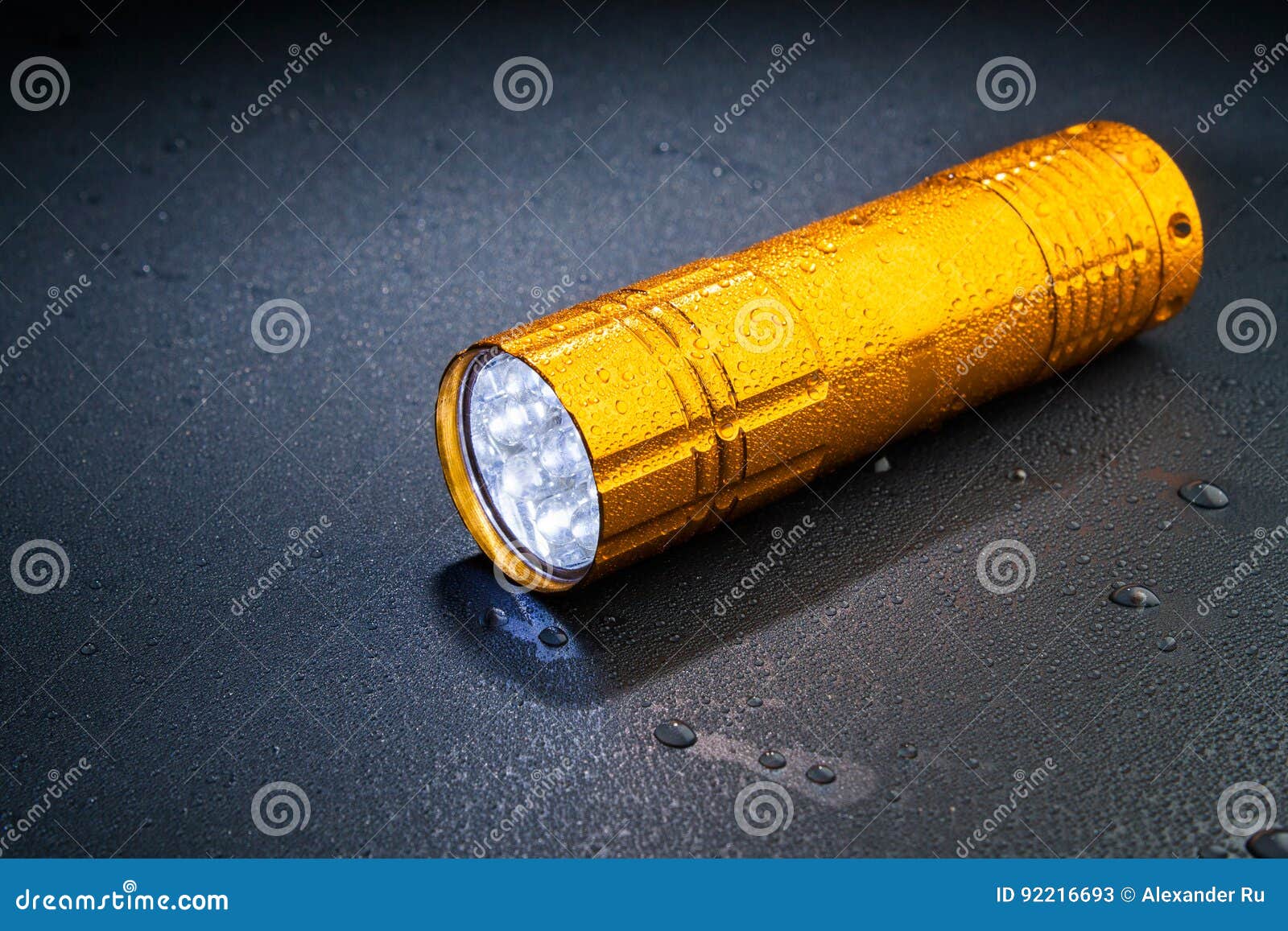 Pocket LED Flashlight in the Rain on a Dark Surface. Water Drops Stock ...