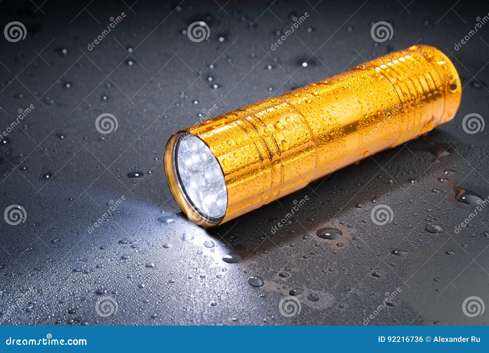 Pocket LED Flashlight in the Rain on a Dark Surface. Water Drops Stock ...