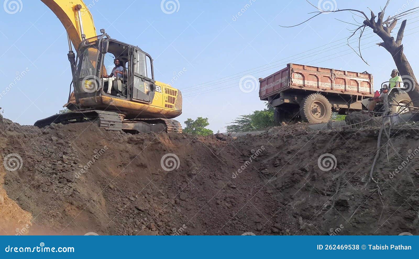 A Poclain Machine Excavator Machine Loads Moorum Soil into a Tractor at ...