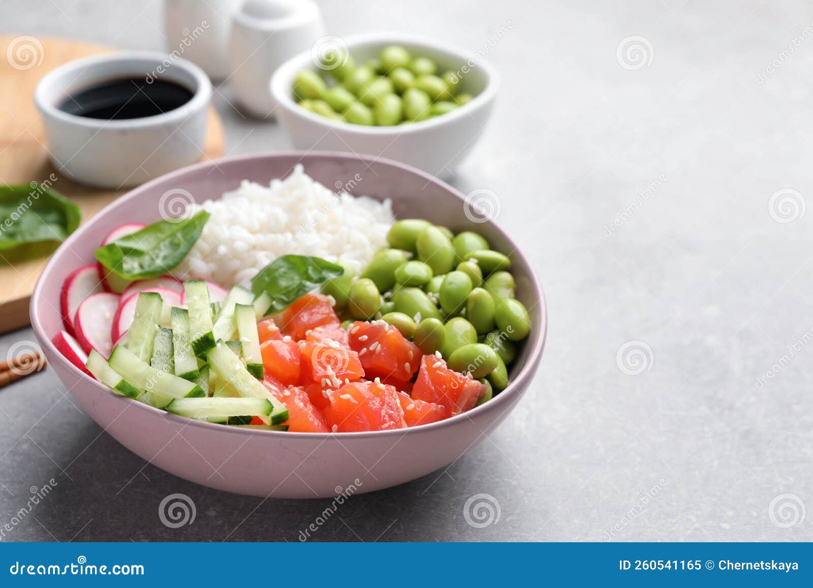 Poke Bowl with Salmon, Edamame Beans and Vegetables on Light Grey Table ...