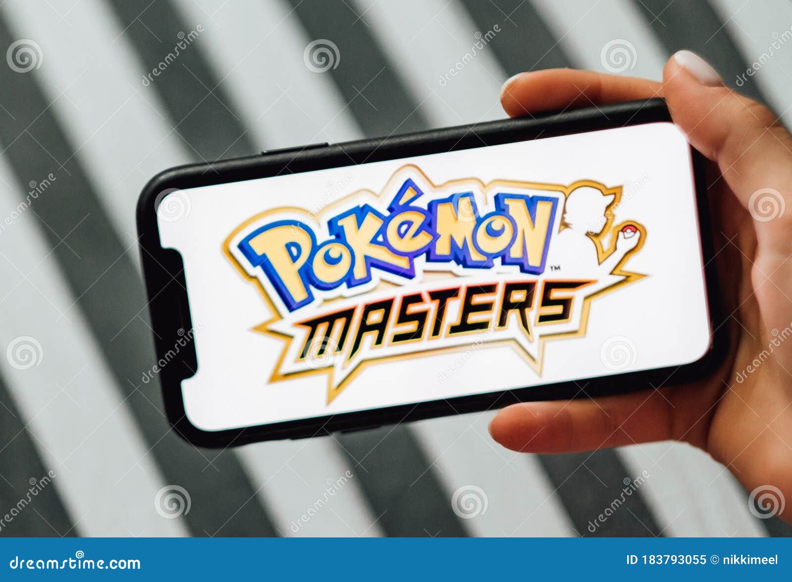 Hands Holding IPhone with Pokemon Masters on the Screen. Editorial ...